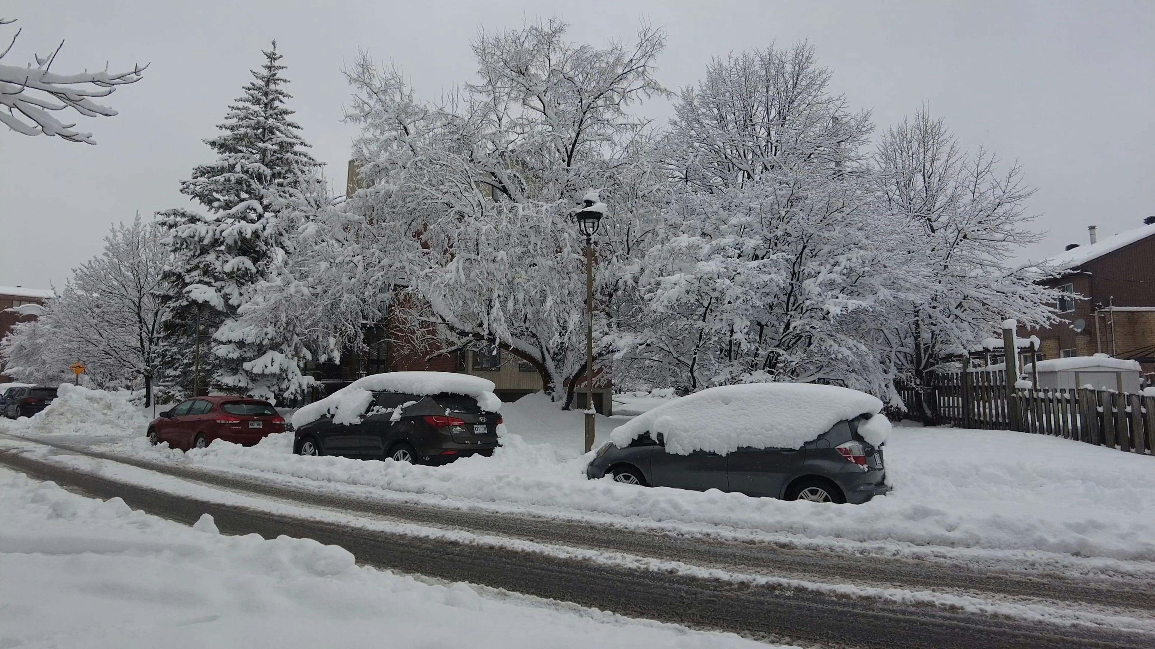 A Man In Black Winter Clothes Walking On A Road Heavily Covered In Snow ...