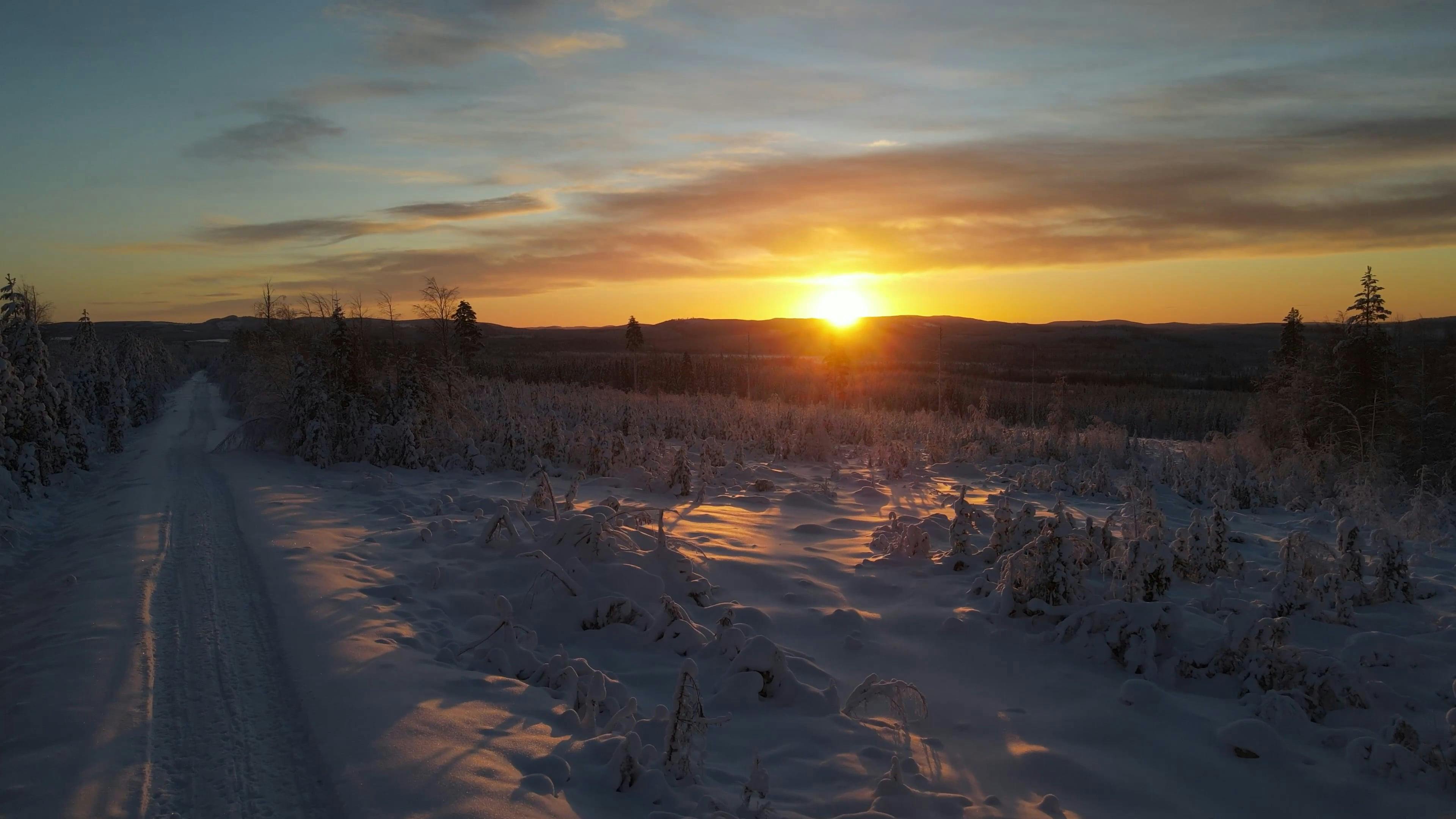 The sun setting over a snowy field with trees Free Stock Video Footage ...
