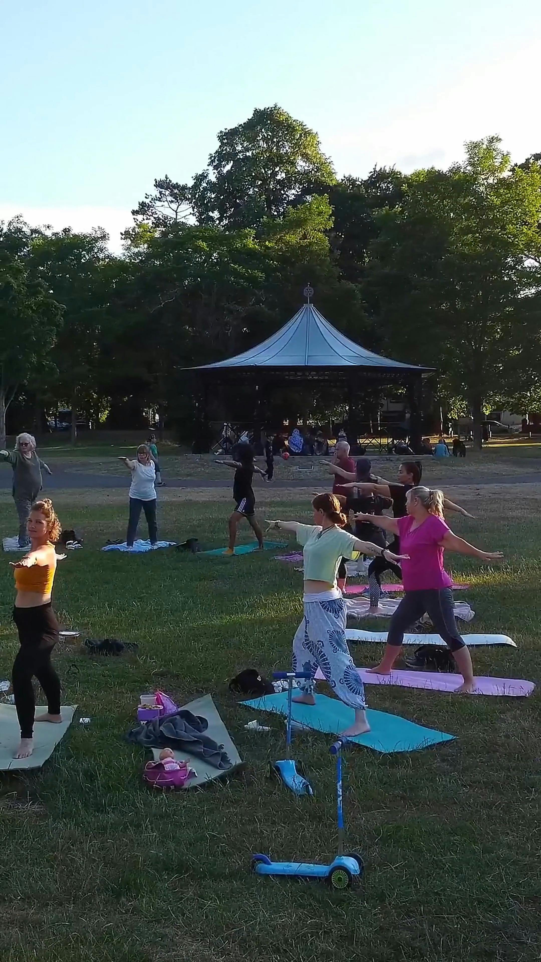 open air yoga class to group of young ladies at park of Luton England ...