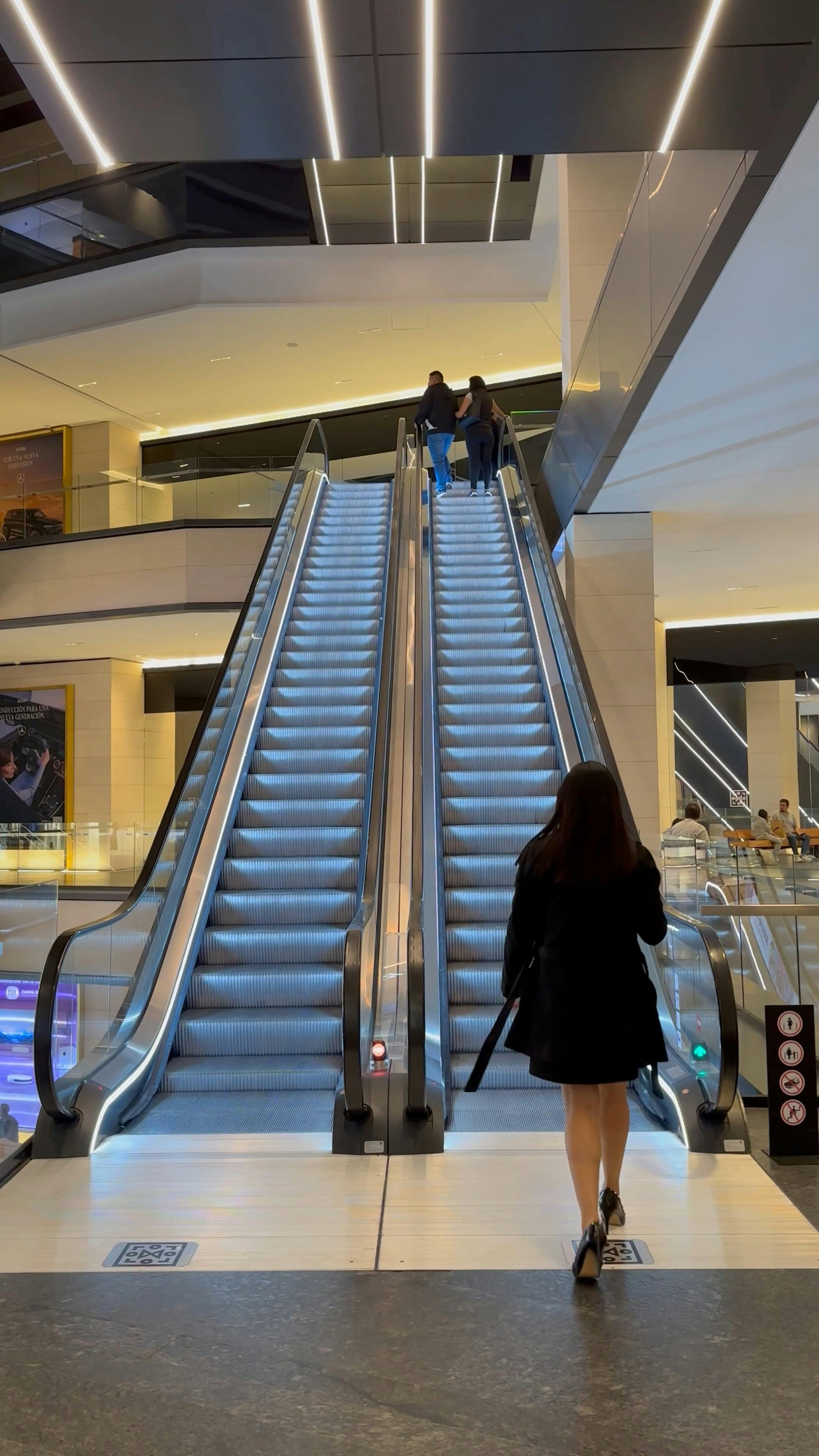 An escalator in a shopping mall with people walking on it Free Stock ...