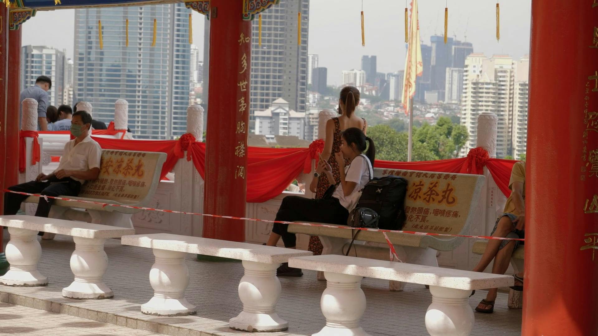 People sitting on benches in front of a chinese temple Free Stock Video ...