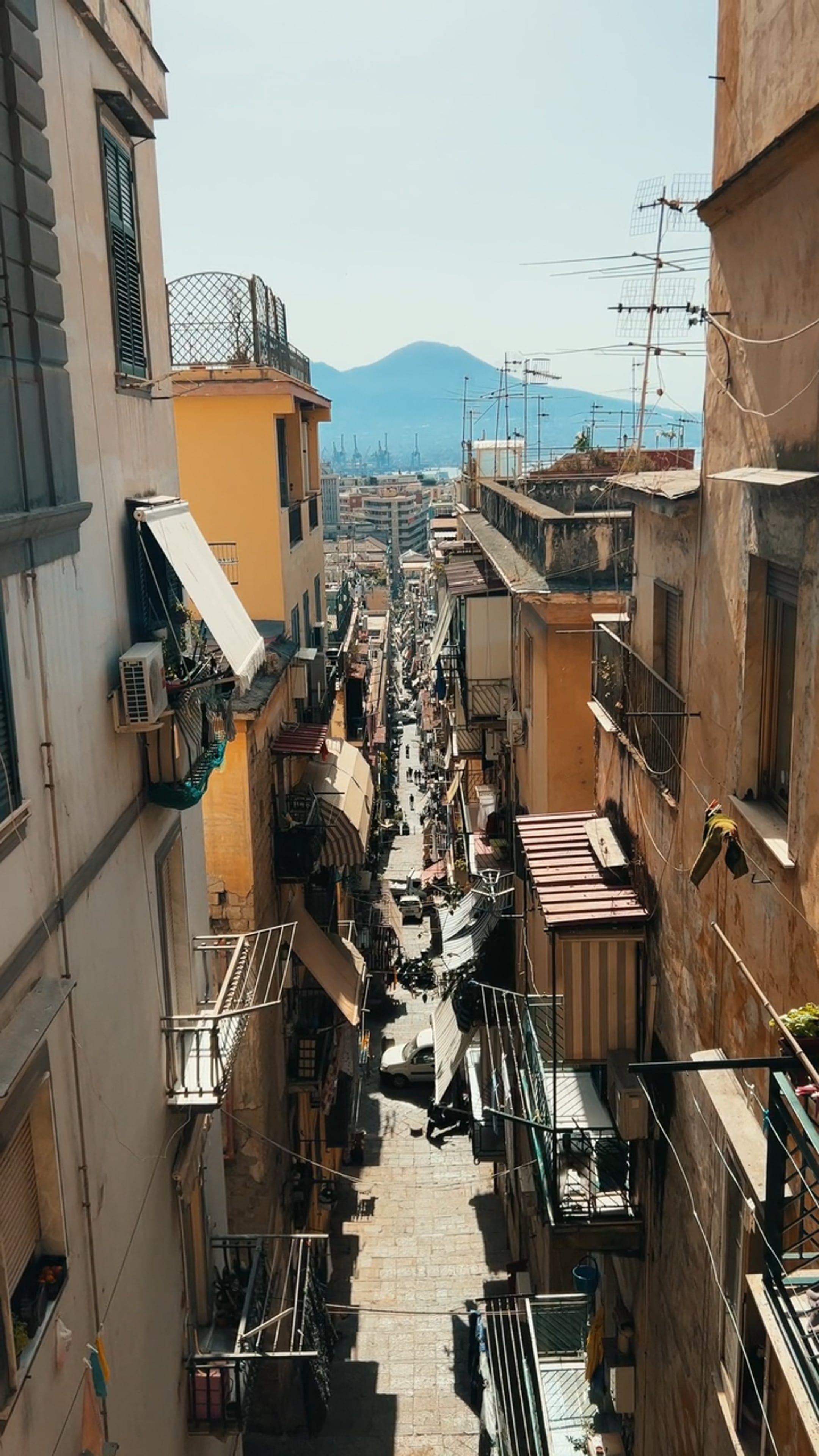 A narrow alley with buildings and people walking down it Free Stock ...