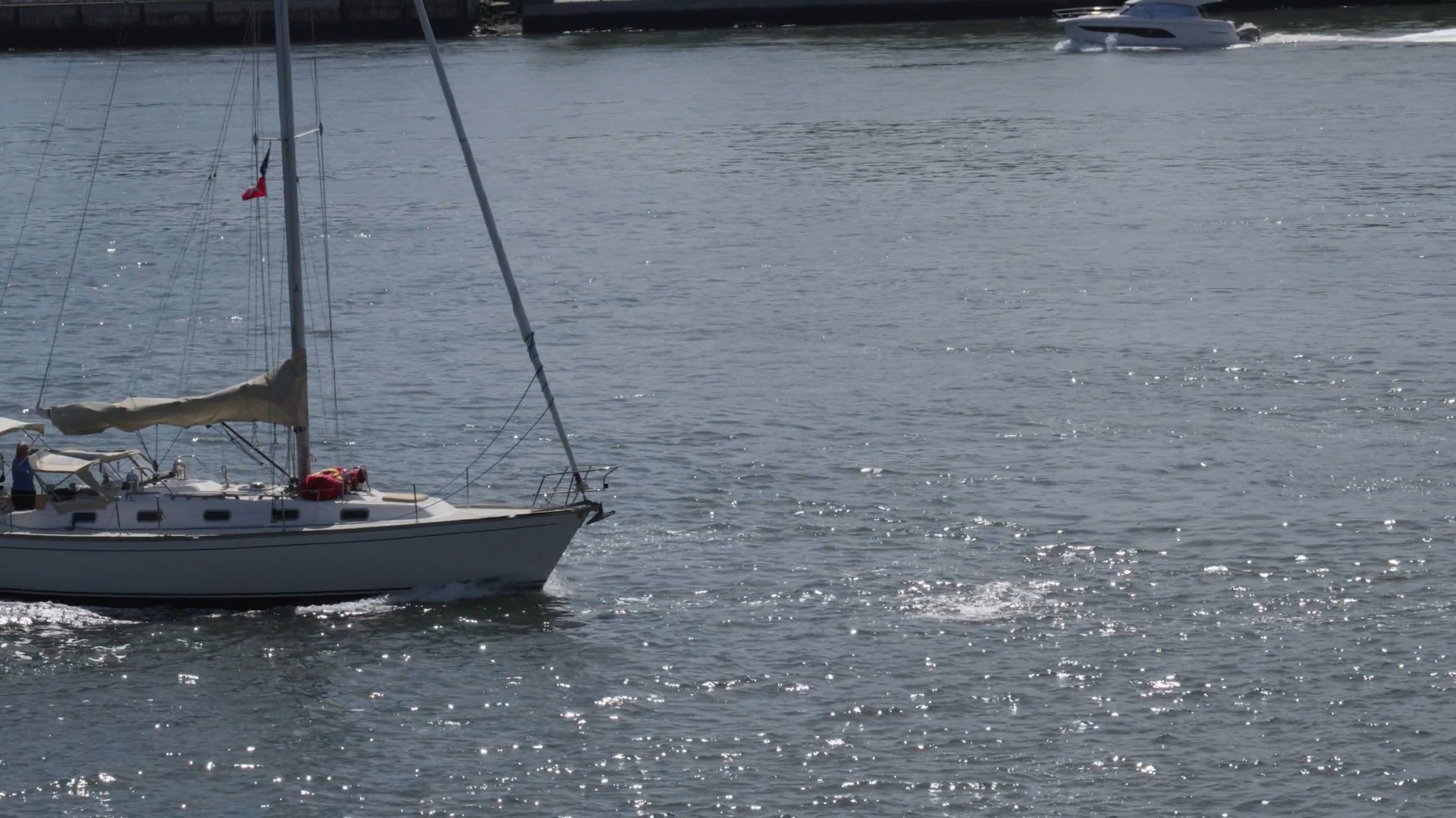 A white sailing yacht sailboat underway on the glistening gray waters ...