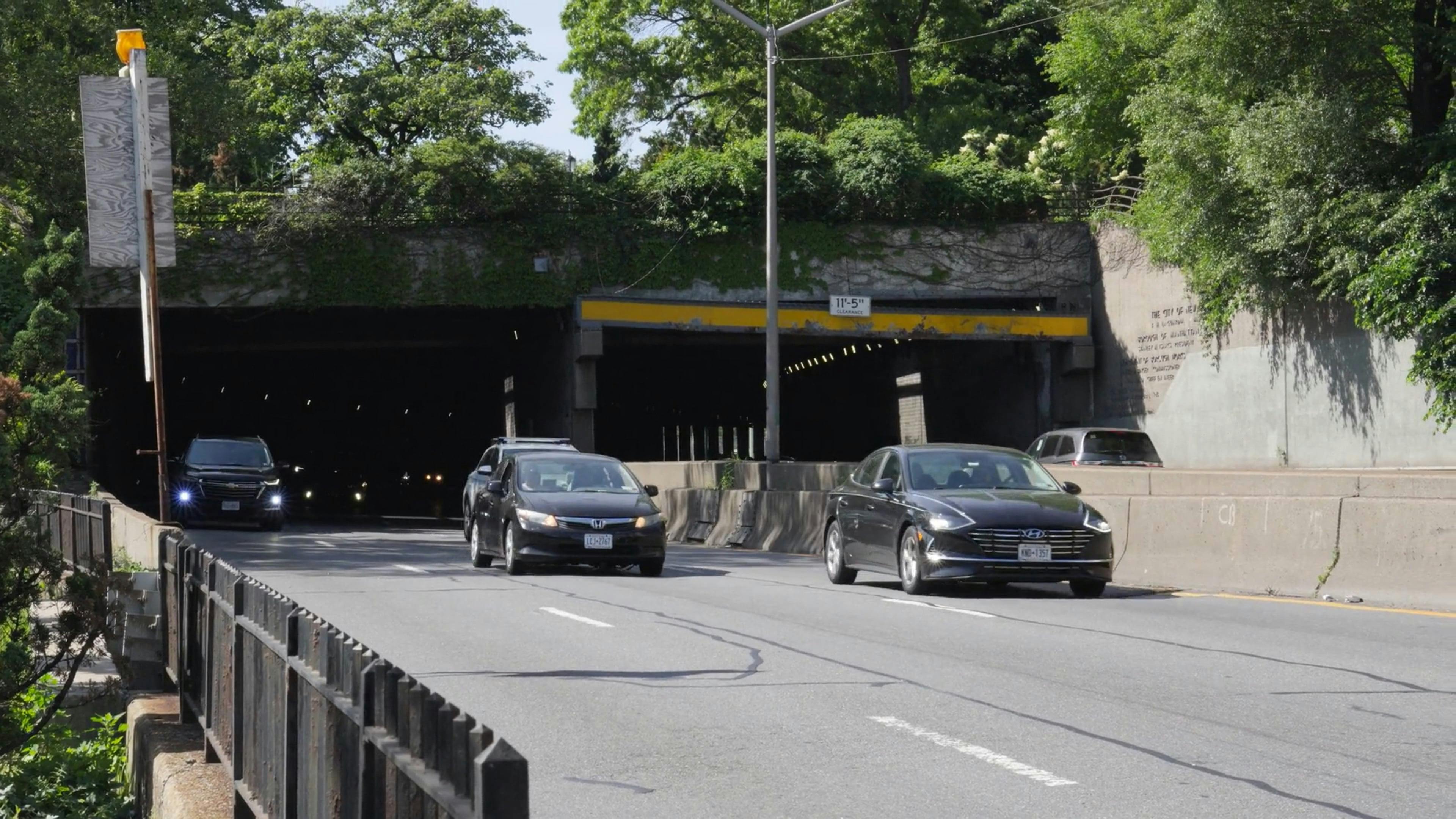 Speeding multicolored cars trucks and SUV motor vehicles exit a dark ...