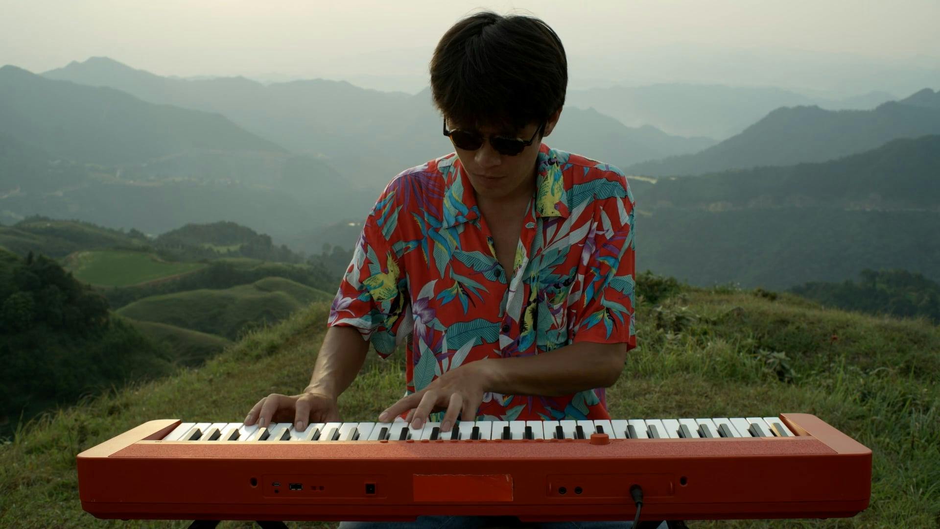 A man in a shirt and sunglasses playing an orange keyboard Free Stock ...
