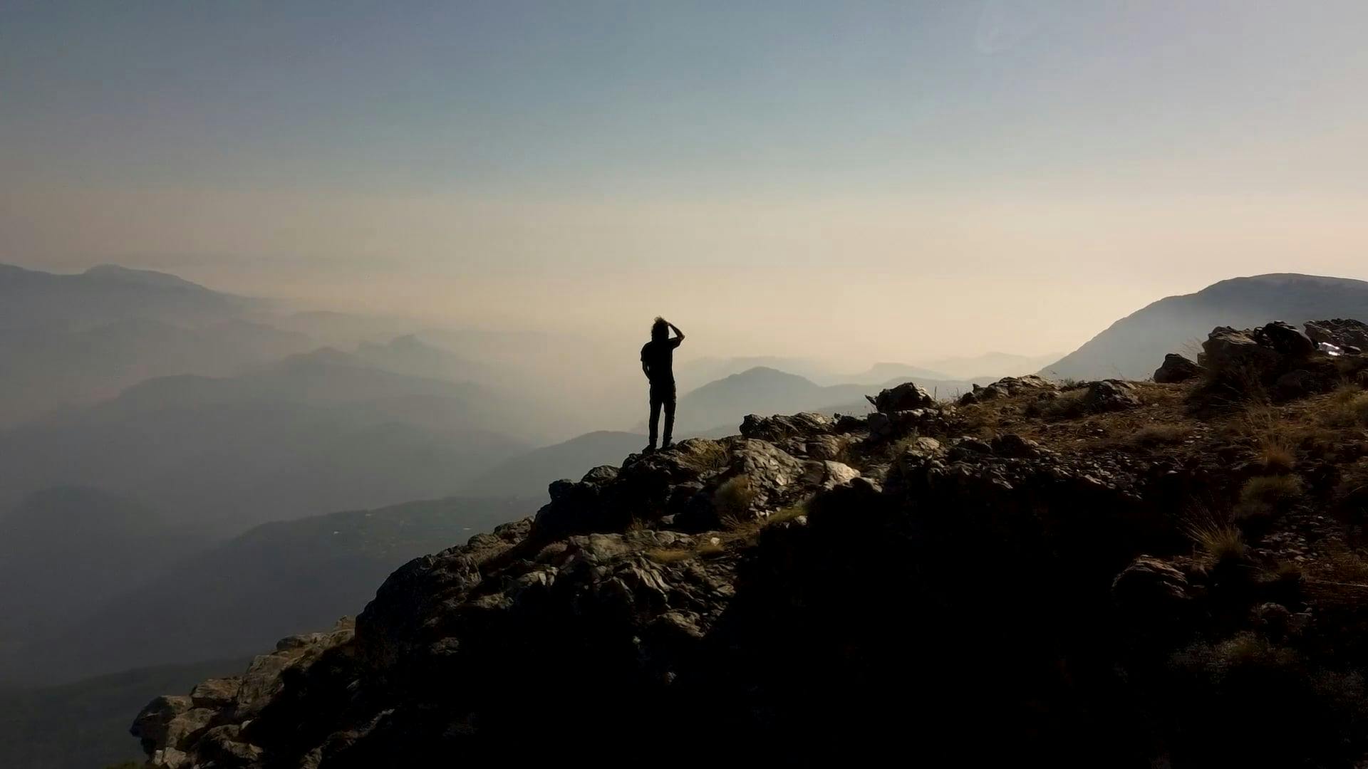 A person standing on top of a mountain with a camera Free Stock Video ...