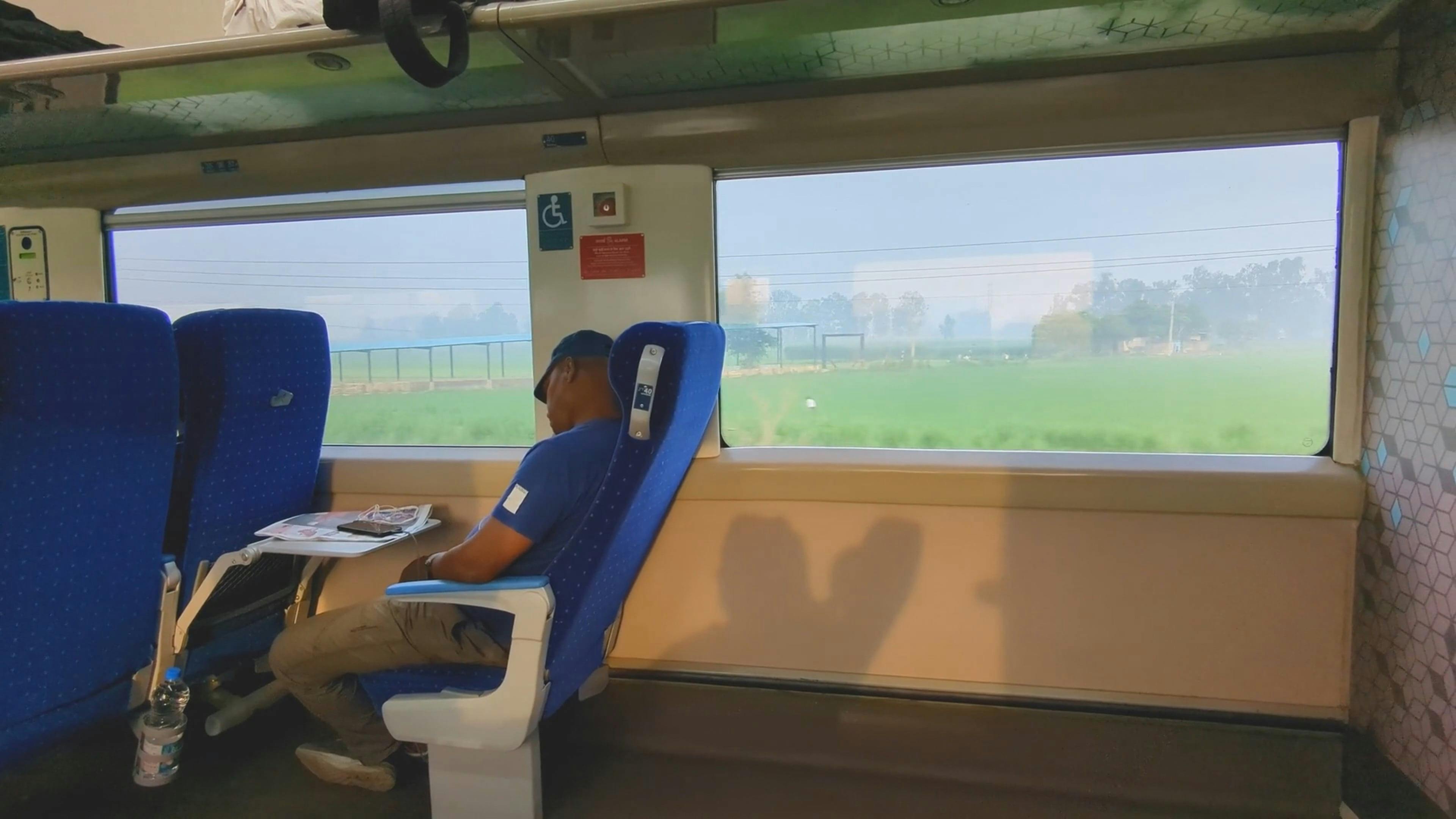 An Indian man sleeping on seat in a chair car train of Vande bharat ...