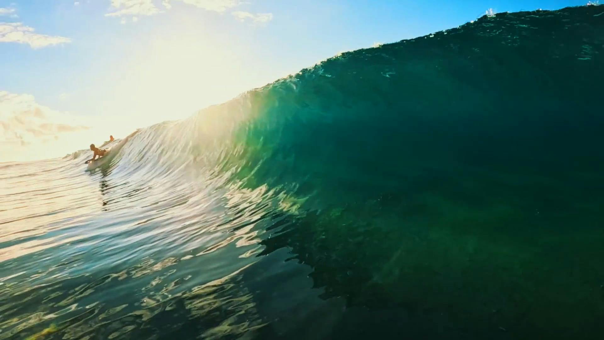 A wave breaking on the beach with surfers in the water Free Stock Video ...