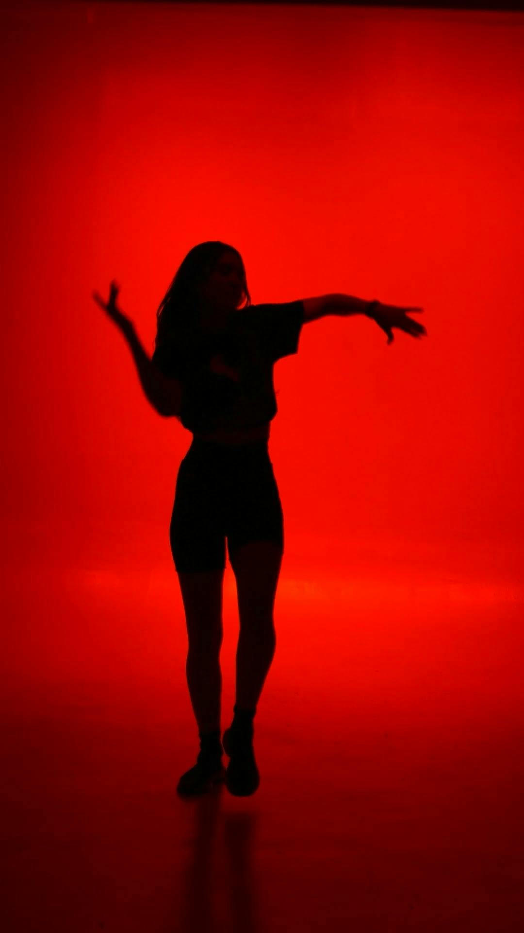 A woman in red standing in front of a red light Free Stock Video ...