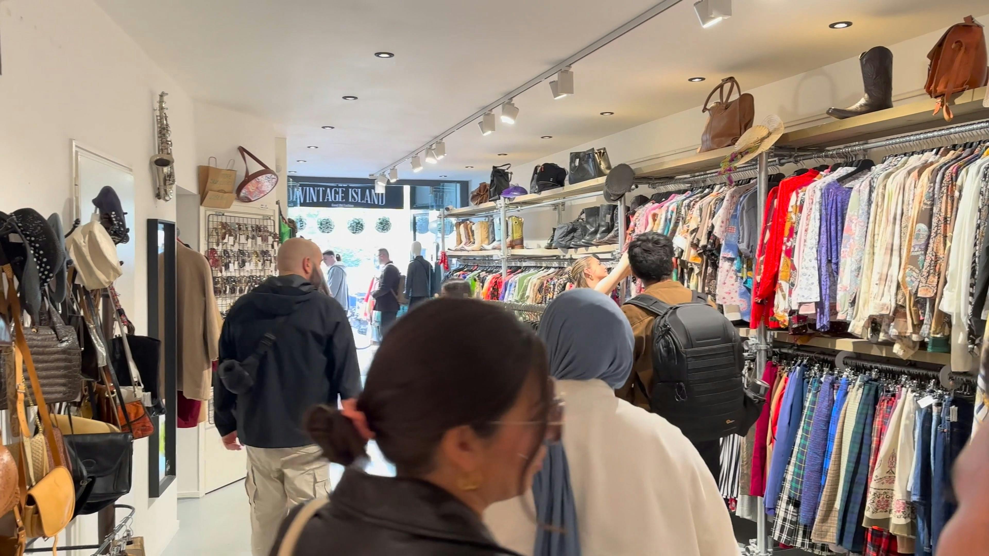 A group of people walking through a store with clothes Free Stock Video ...