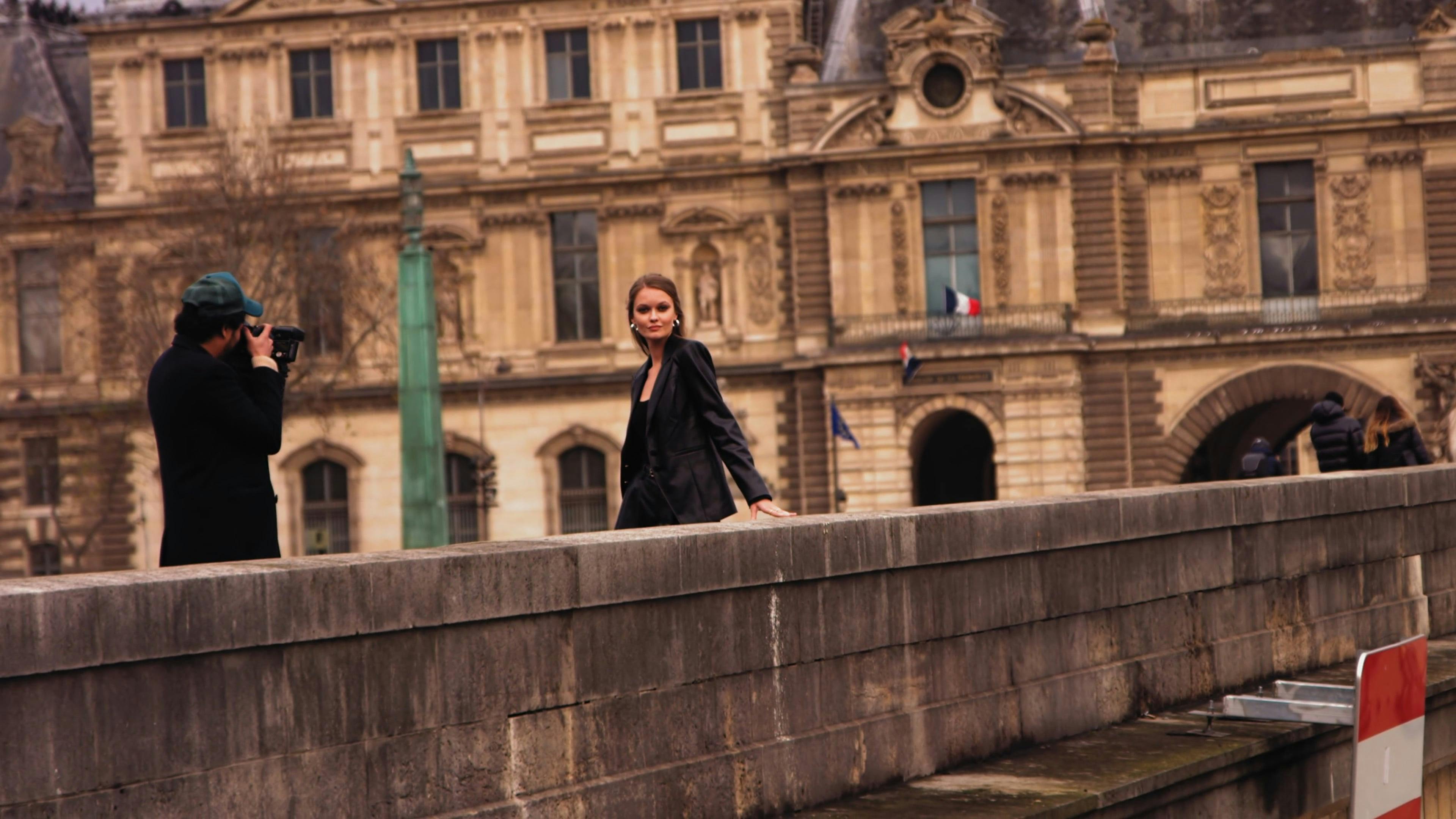 A woman is standing on a bridge in front of a building Free Stock Video ...