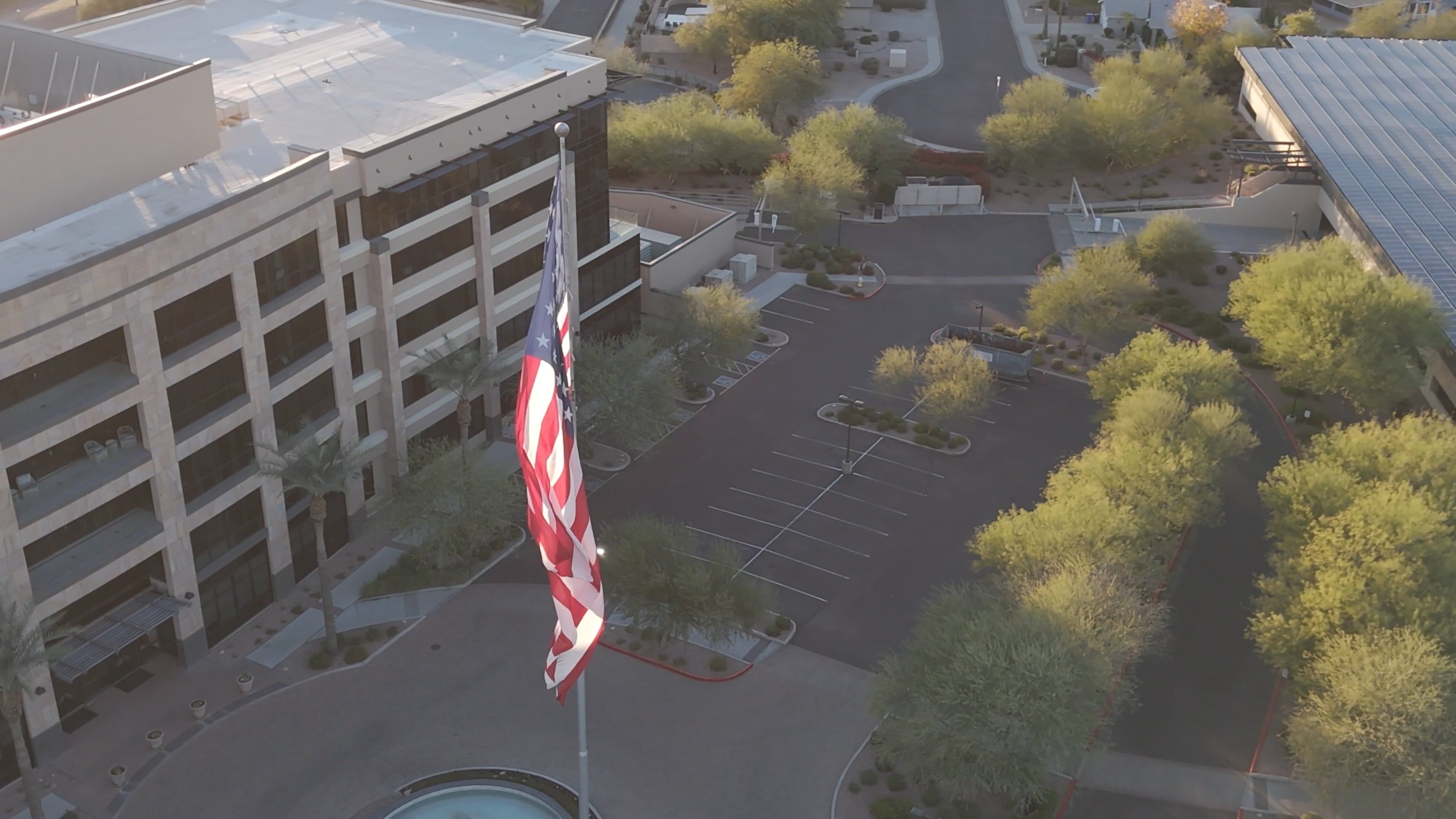 An aerial view of a large flag flying in front of a building Free Stock ...