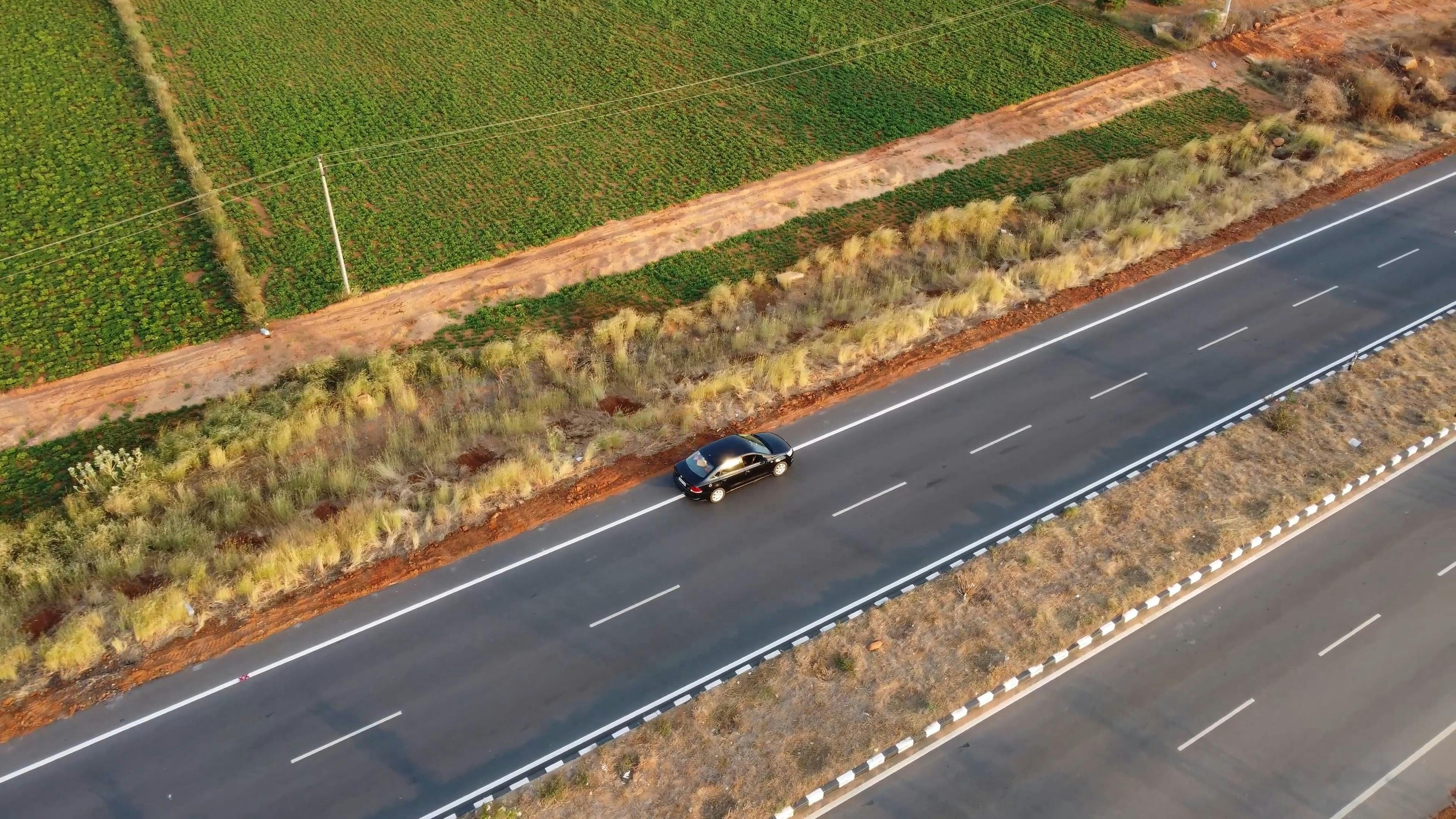 An aerial view of a road with a car driving down it Free Stock Video ...