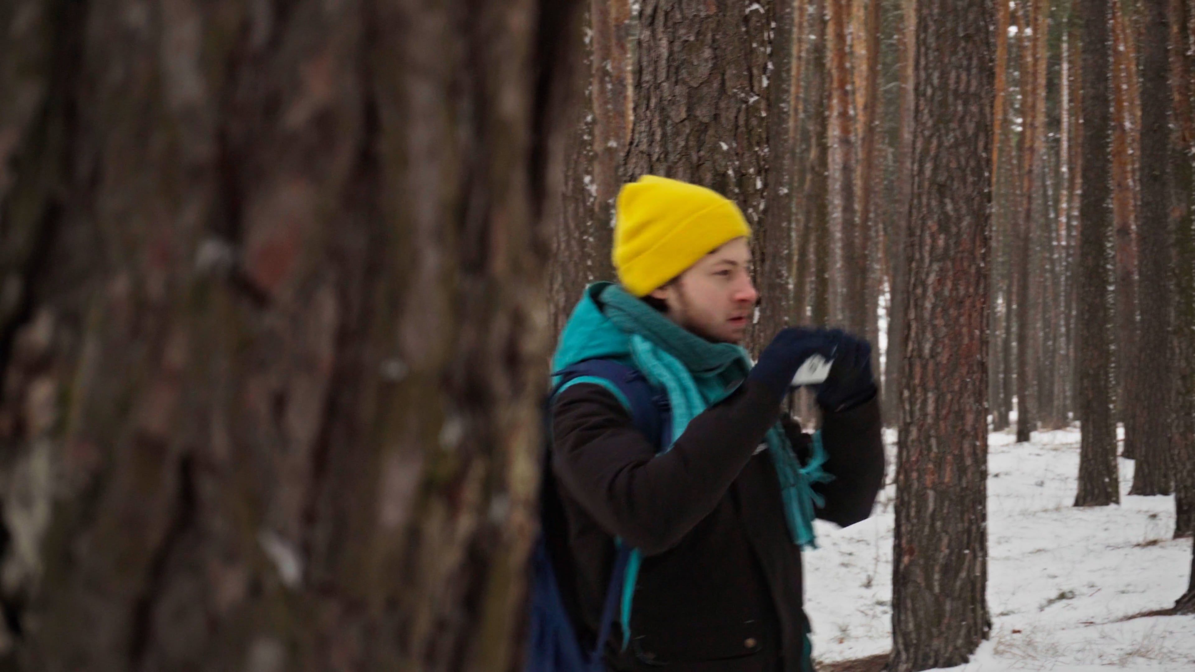 A tourist clad in a bright yellow hat raises a classic film camera ...