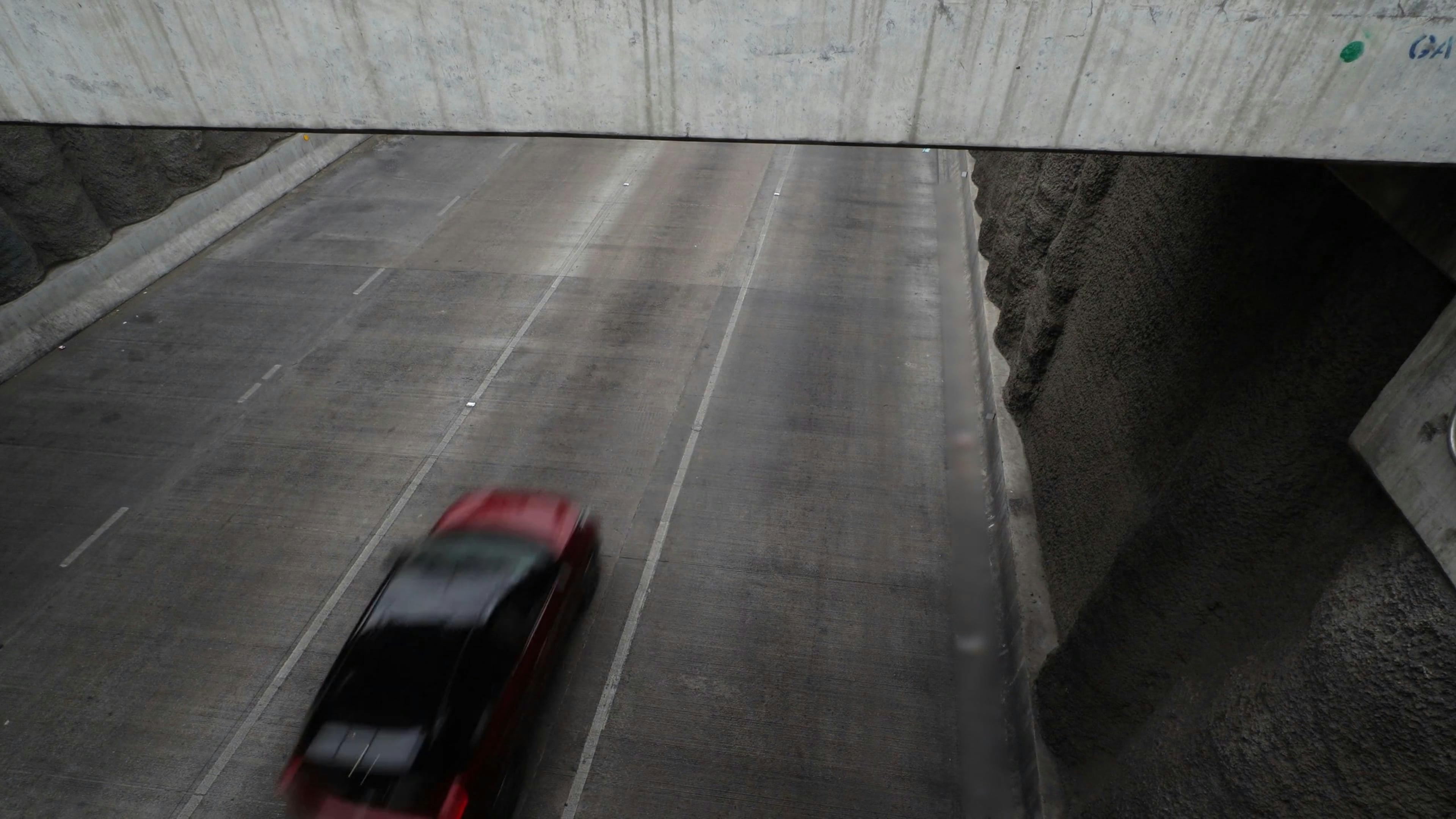 Cars driving under a bridge with a sign that says 'no parking' Free ...