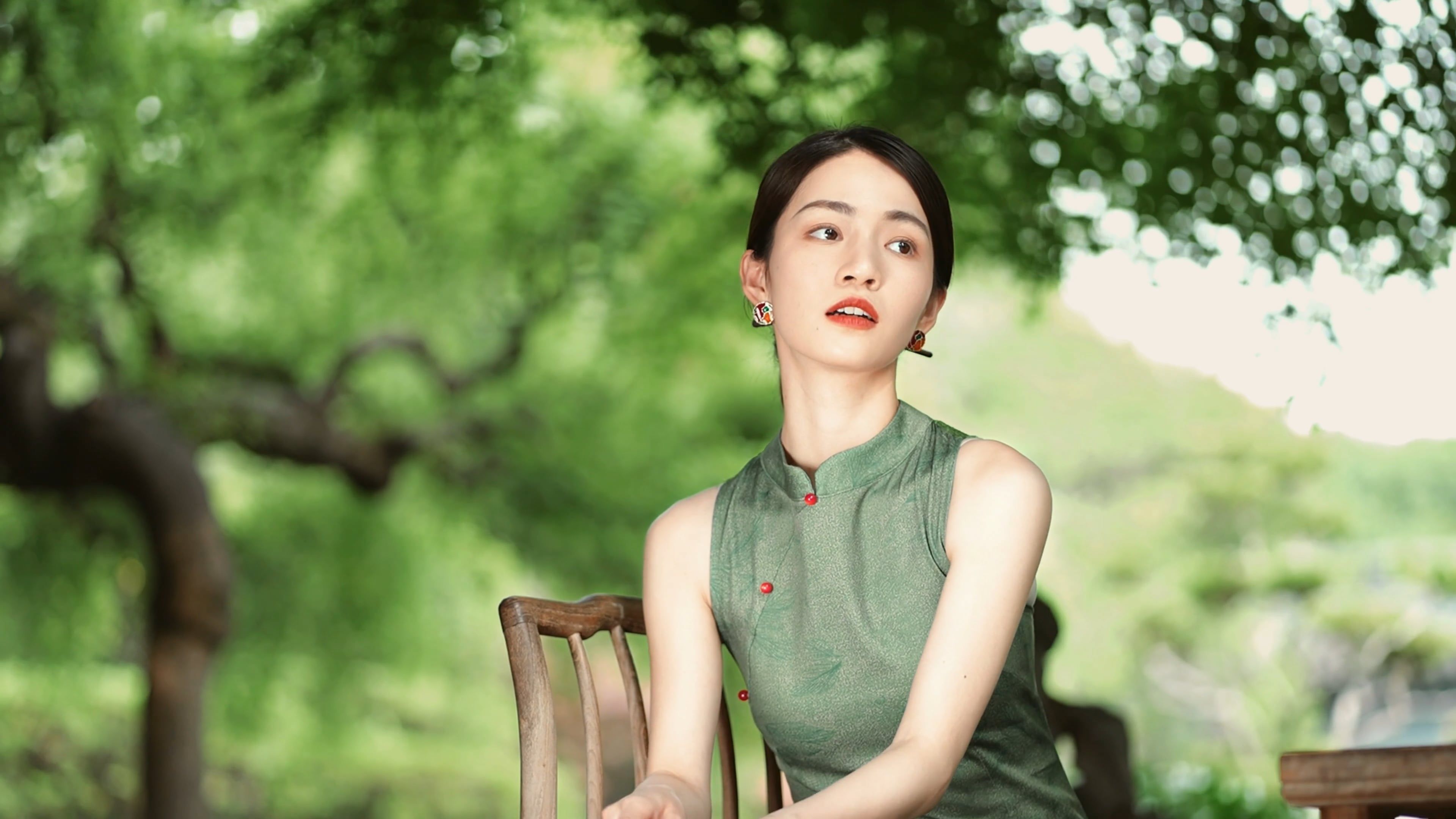 A woman in a green dress sitting on a chair Free Stock Video Footage ...