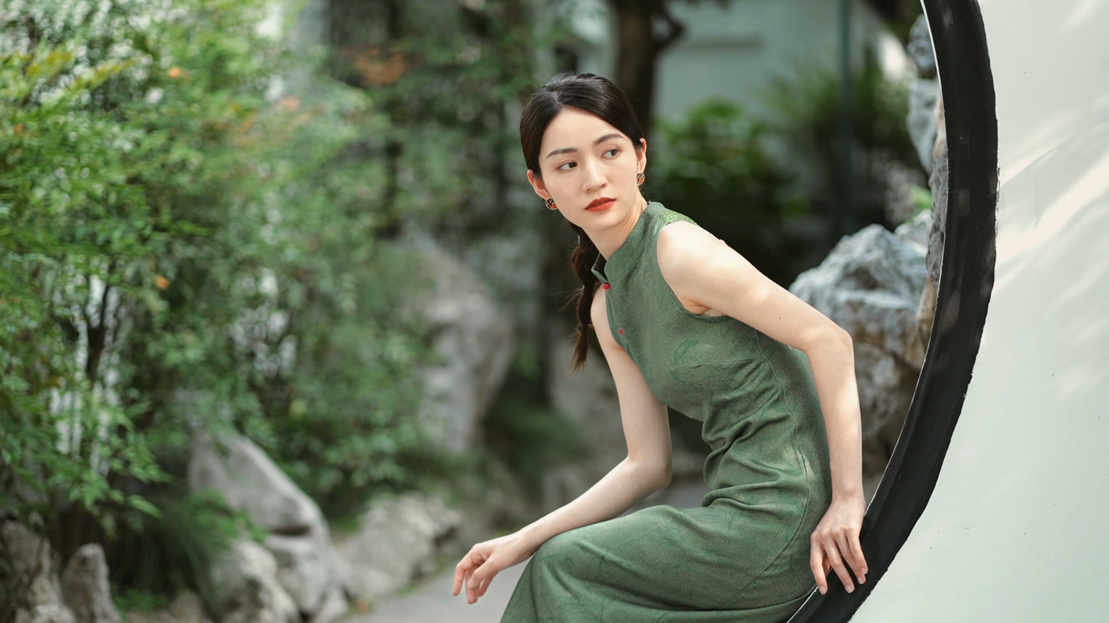 A woman in a green dress sitting on a bench Free Stock Video Footage ...