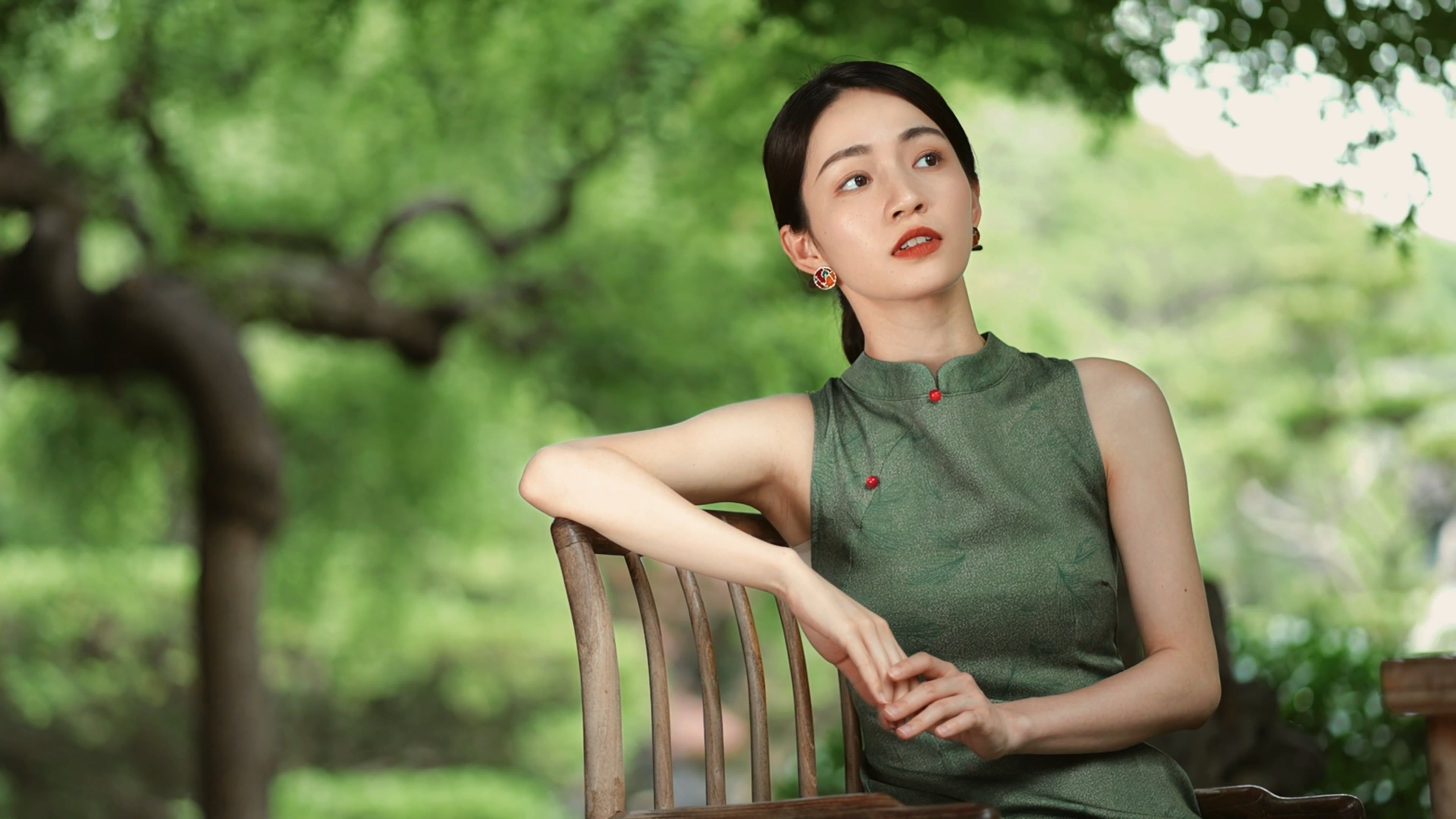 A woman in a green dress sitting on a bench Free Stock Video Footage ...