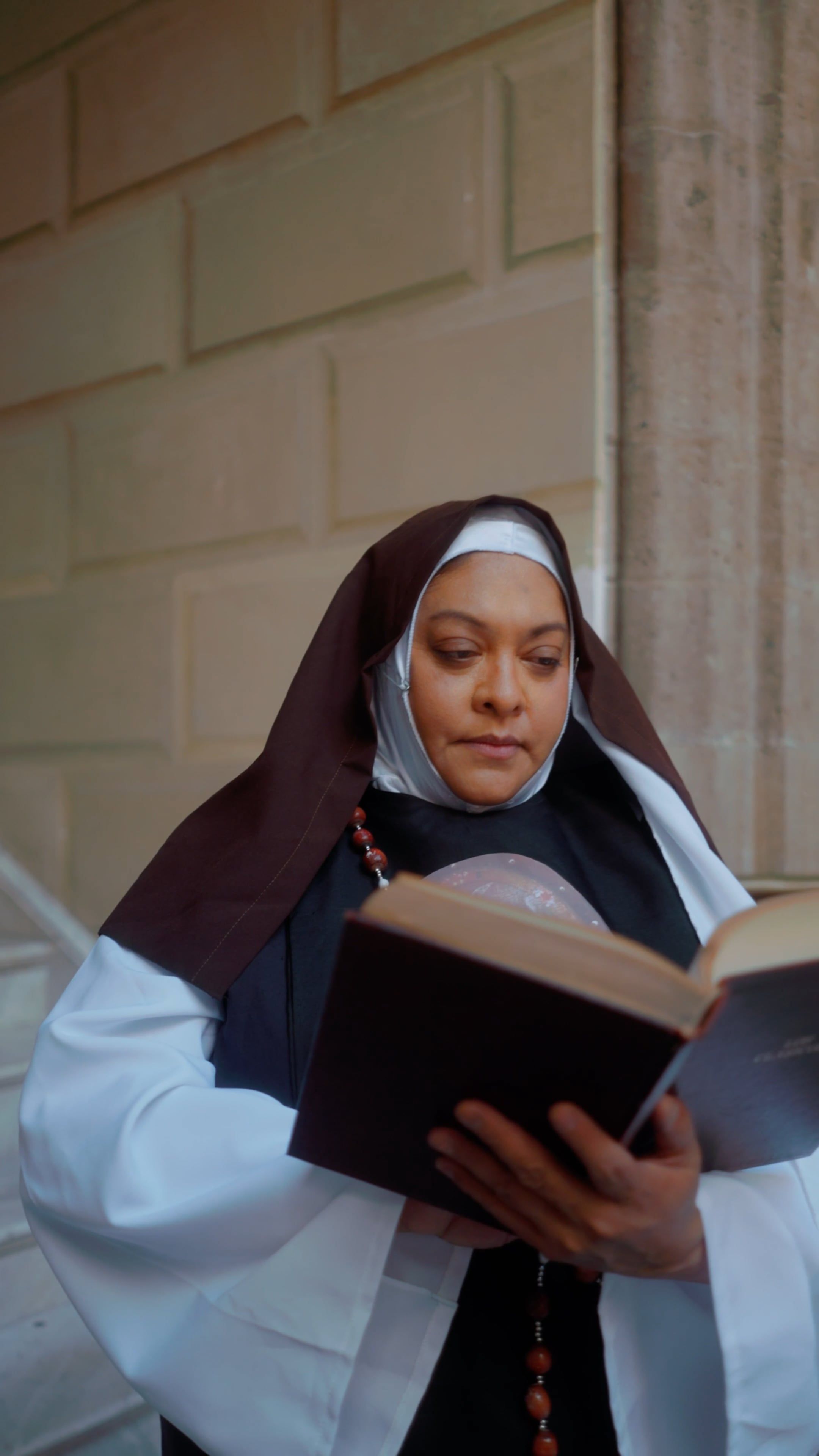A nun reading a book in front of a building Free Stock Video Footage ...