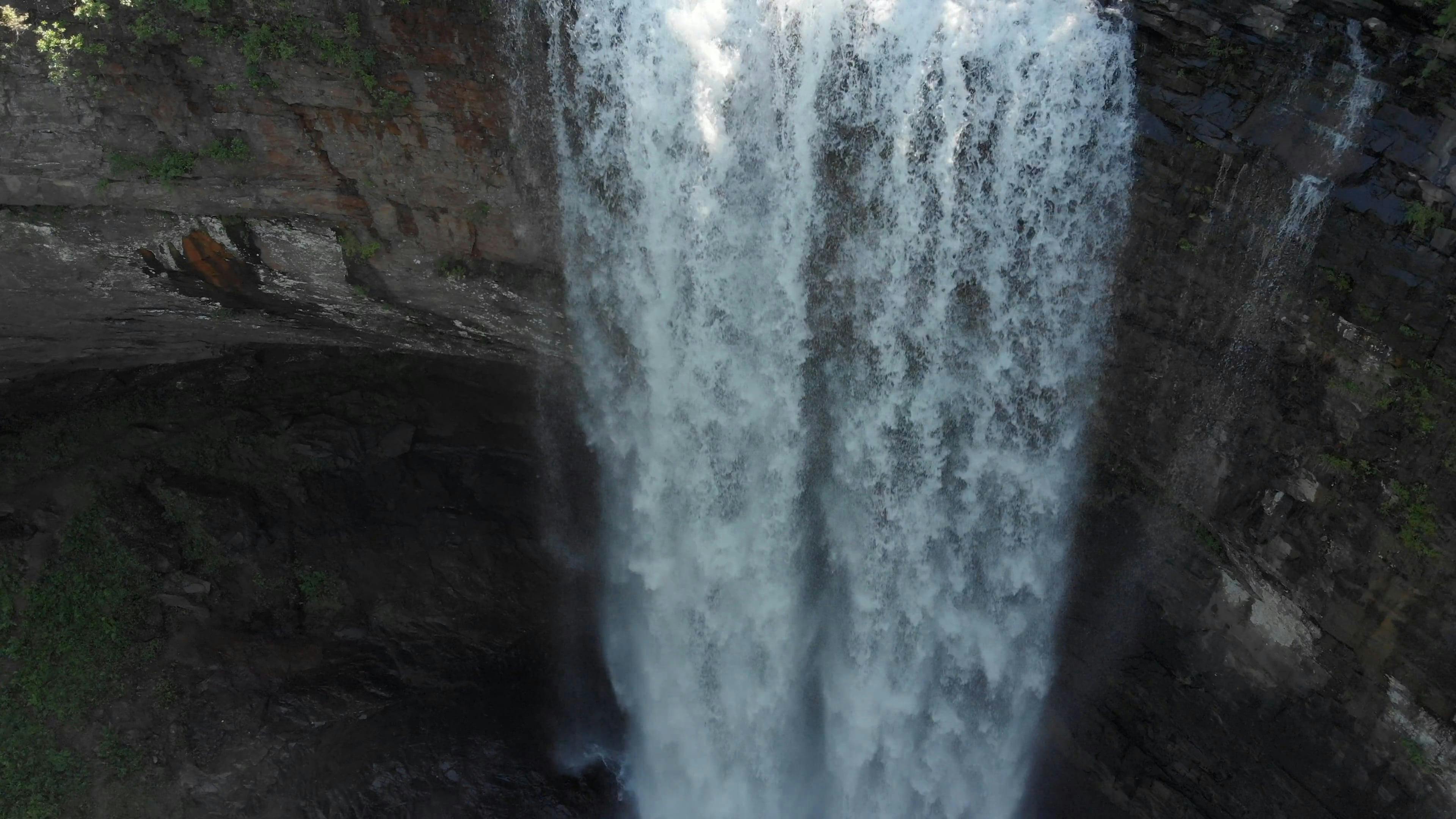 Water Pouring Down A Falls In A Cliff Surrounded By Thick Vegetation ...