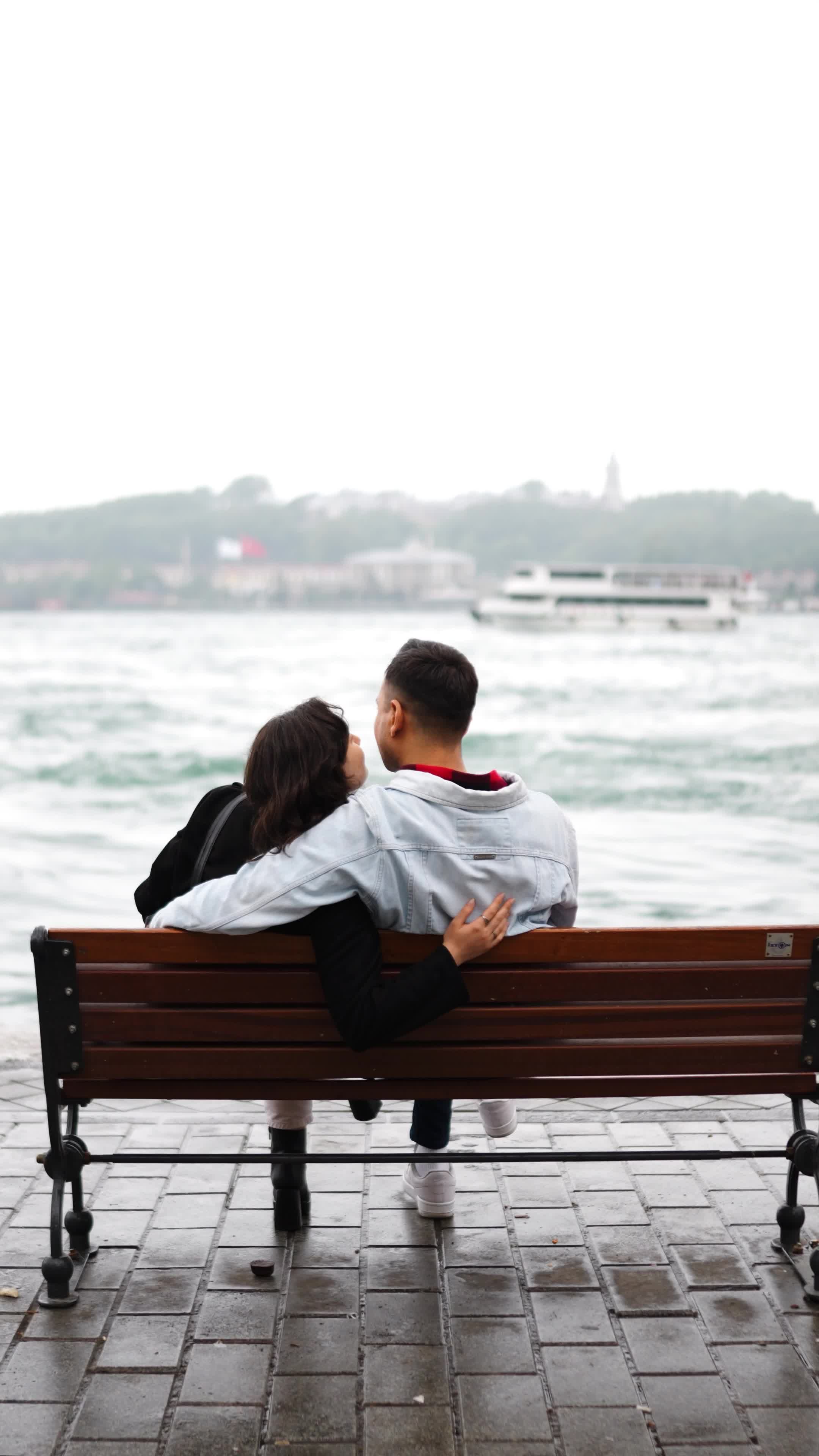 A couple sitting on a bench in front of the ocean Free Stock Video ...