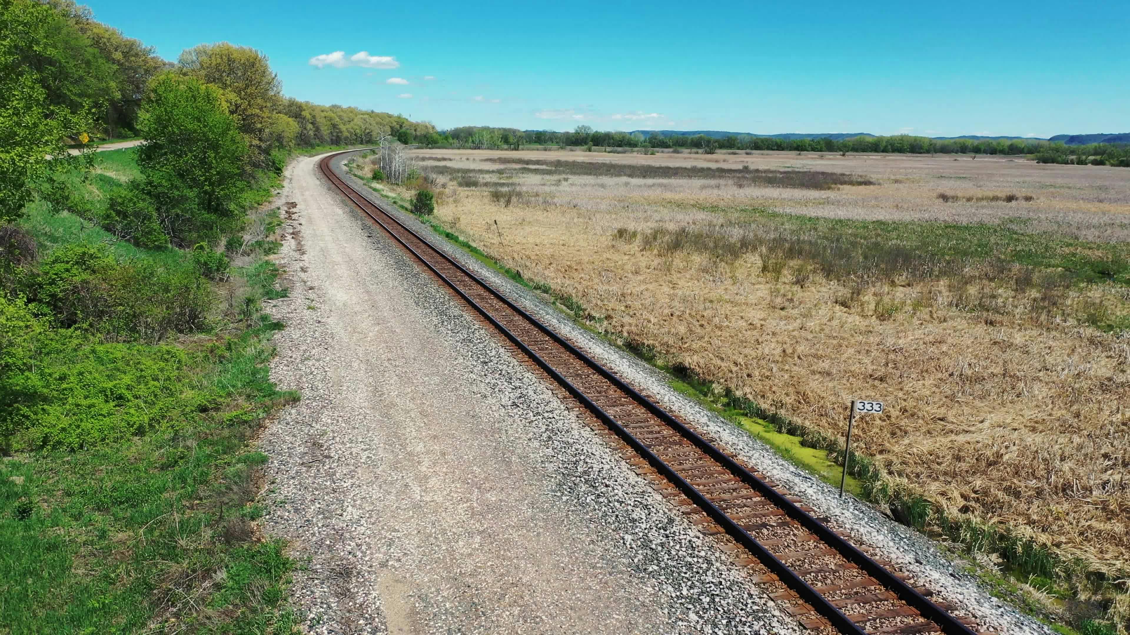 A train track running through a field with a blue sky Free Stock Video ...