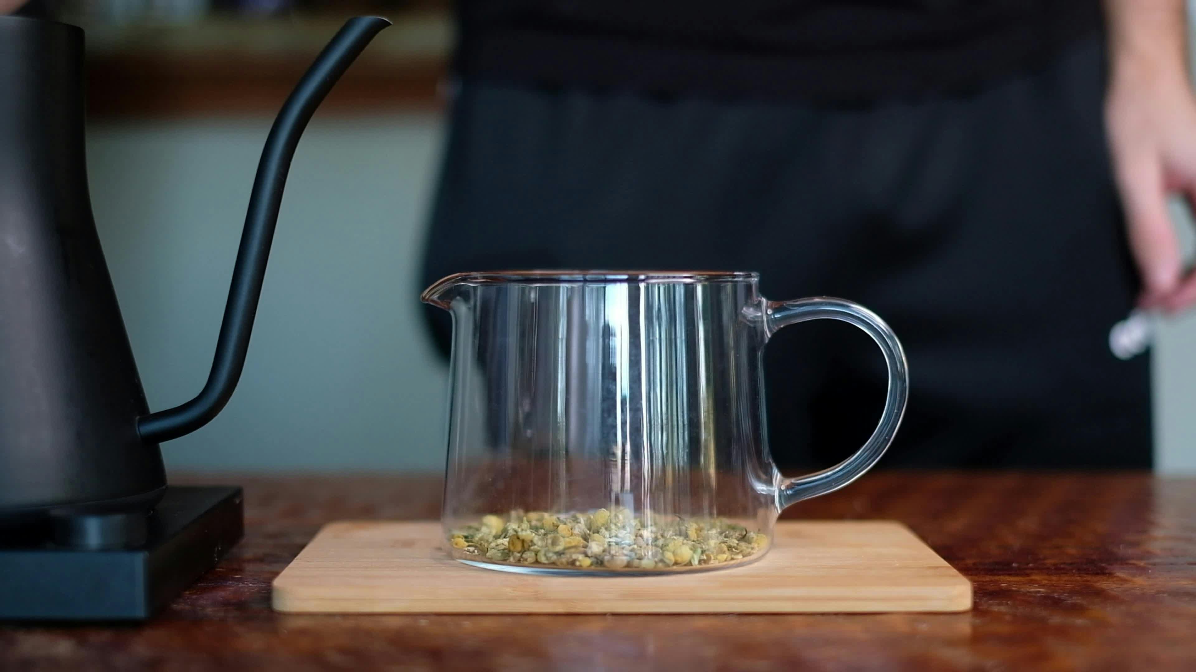 A person pouring tea into a glass pitcher Free Stock Video Footage ...