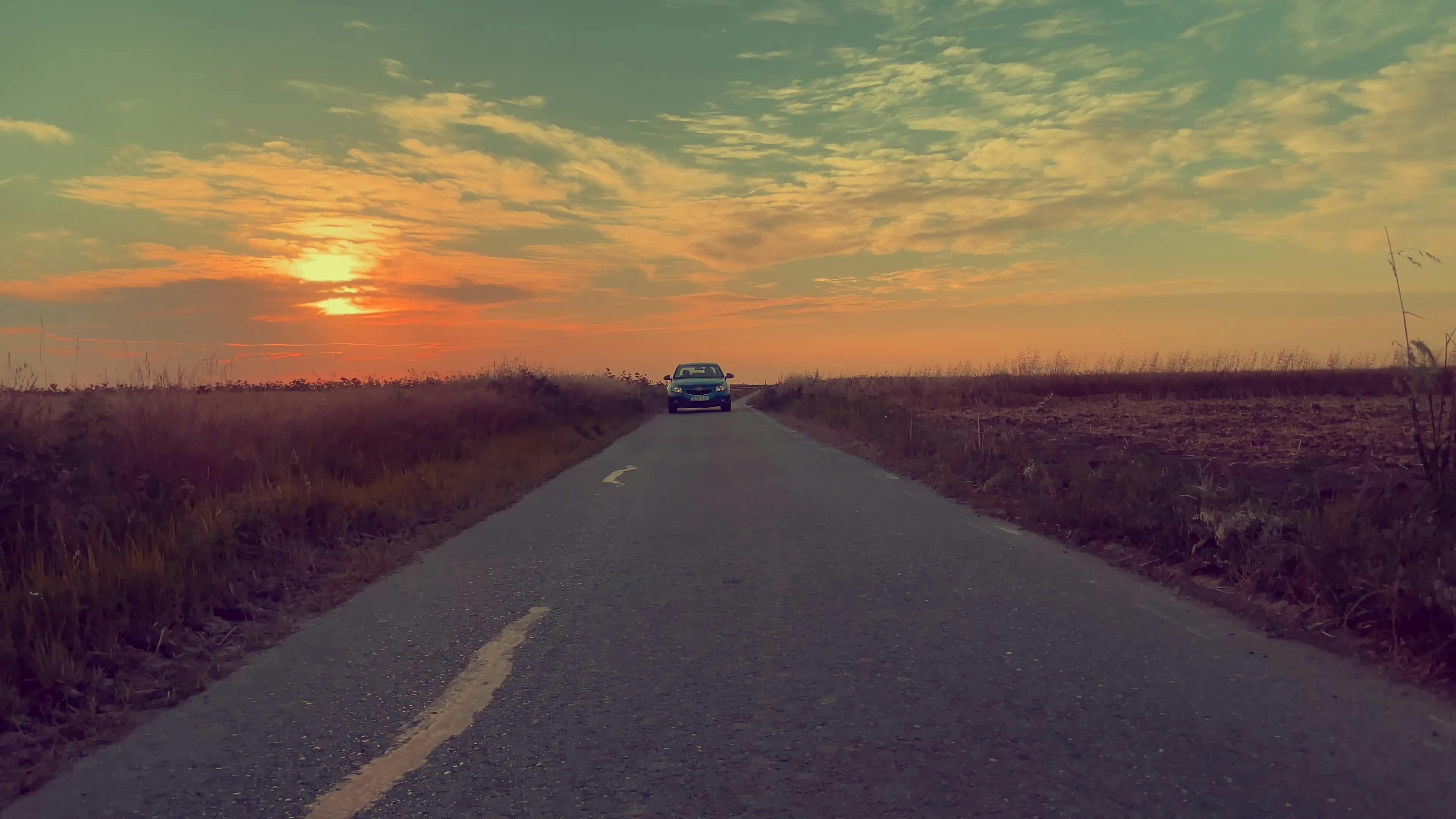 Low angle shot in sunset Chevrolet Cruz car on the road coming towards ...