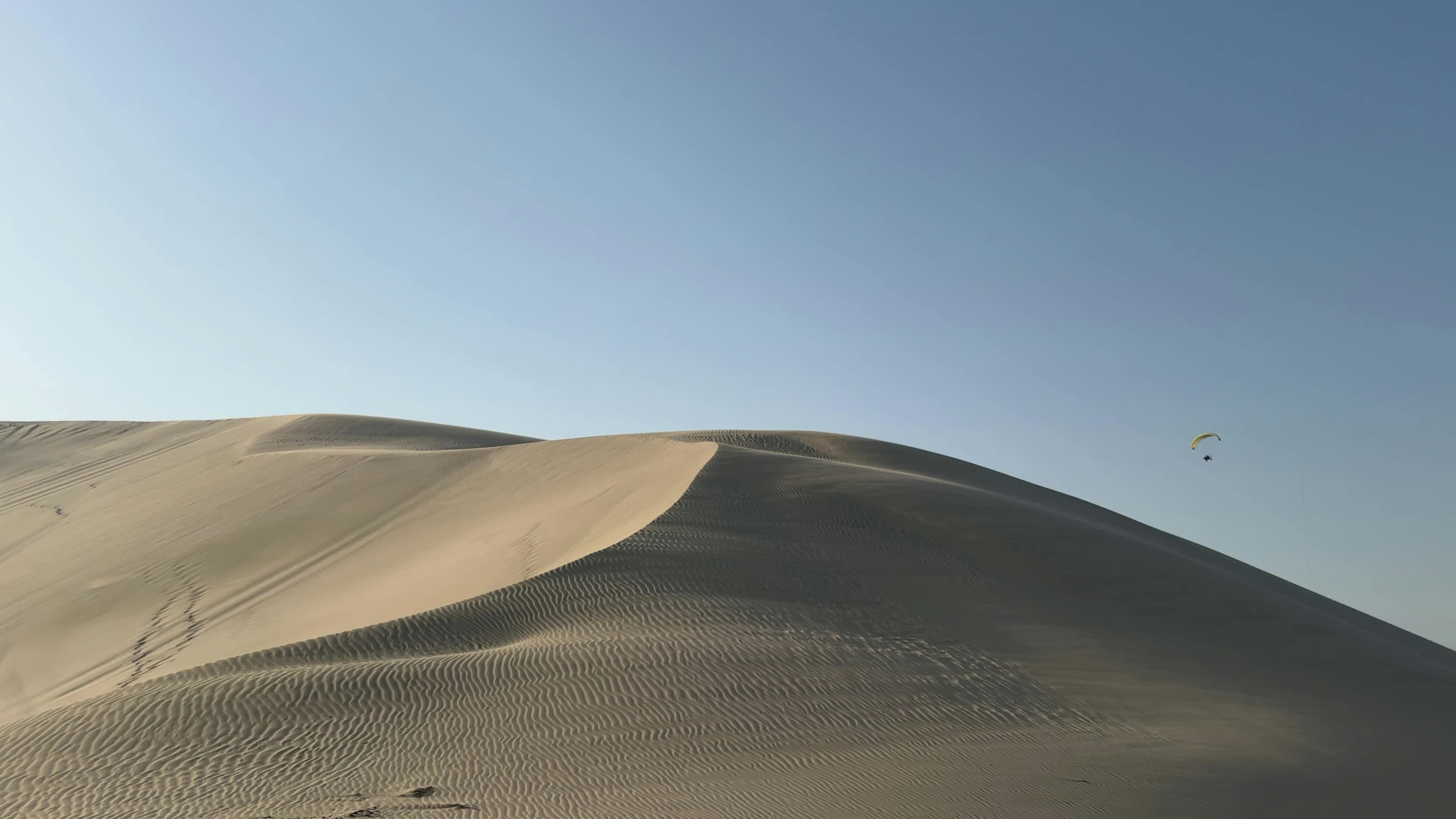 a paramotor flying over desert sand dunes Free Stock Video Footage ...