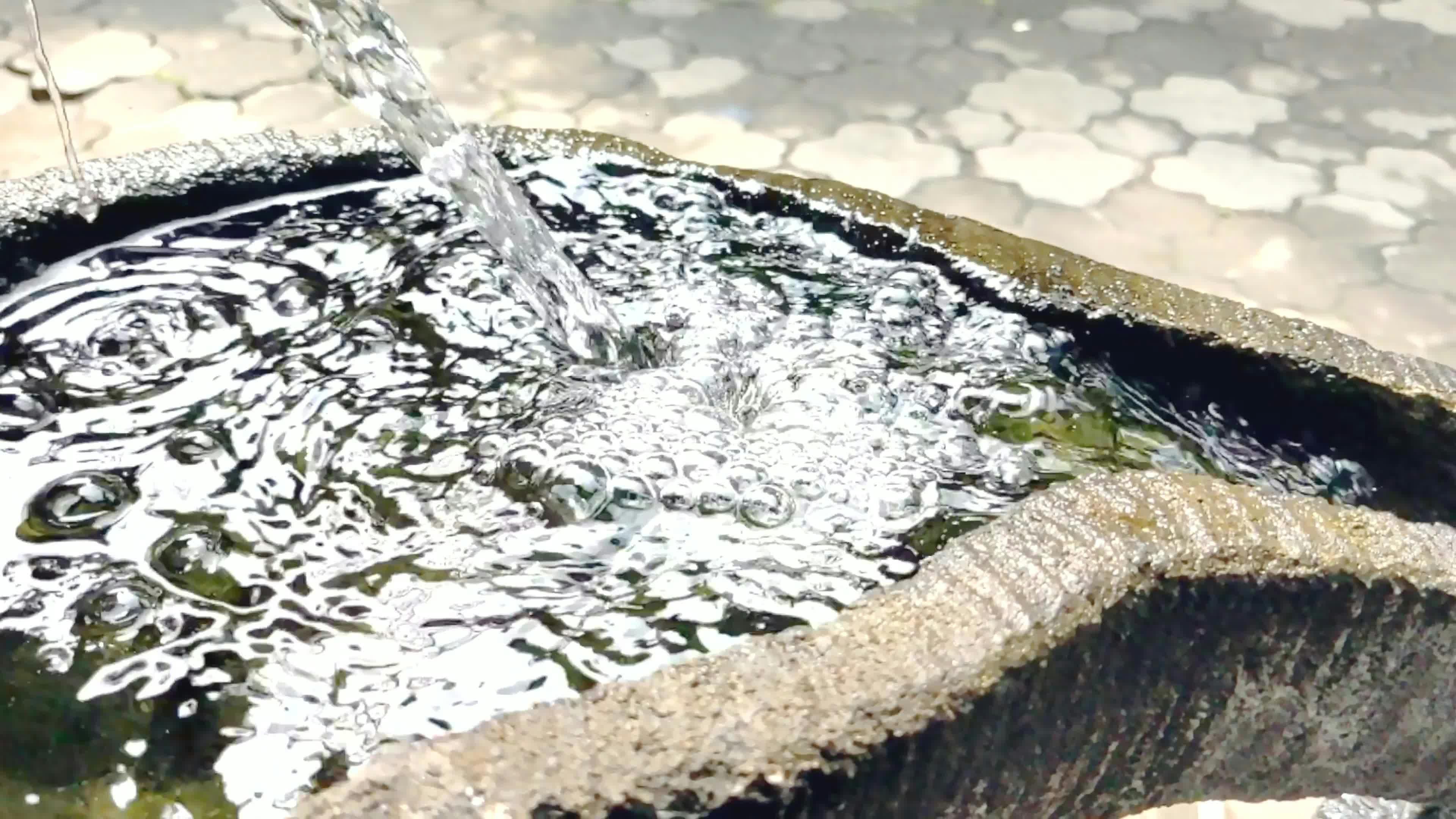 Cinematic shot of a minimalist water feature with a gentle cascading ...