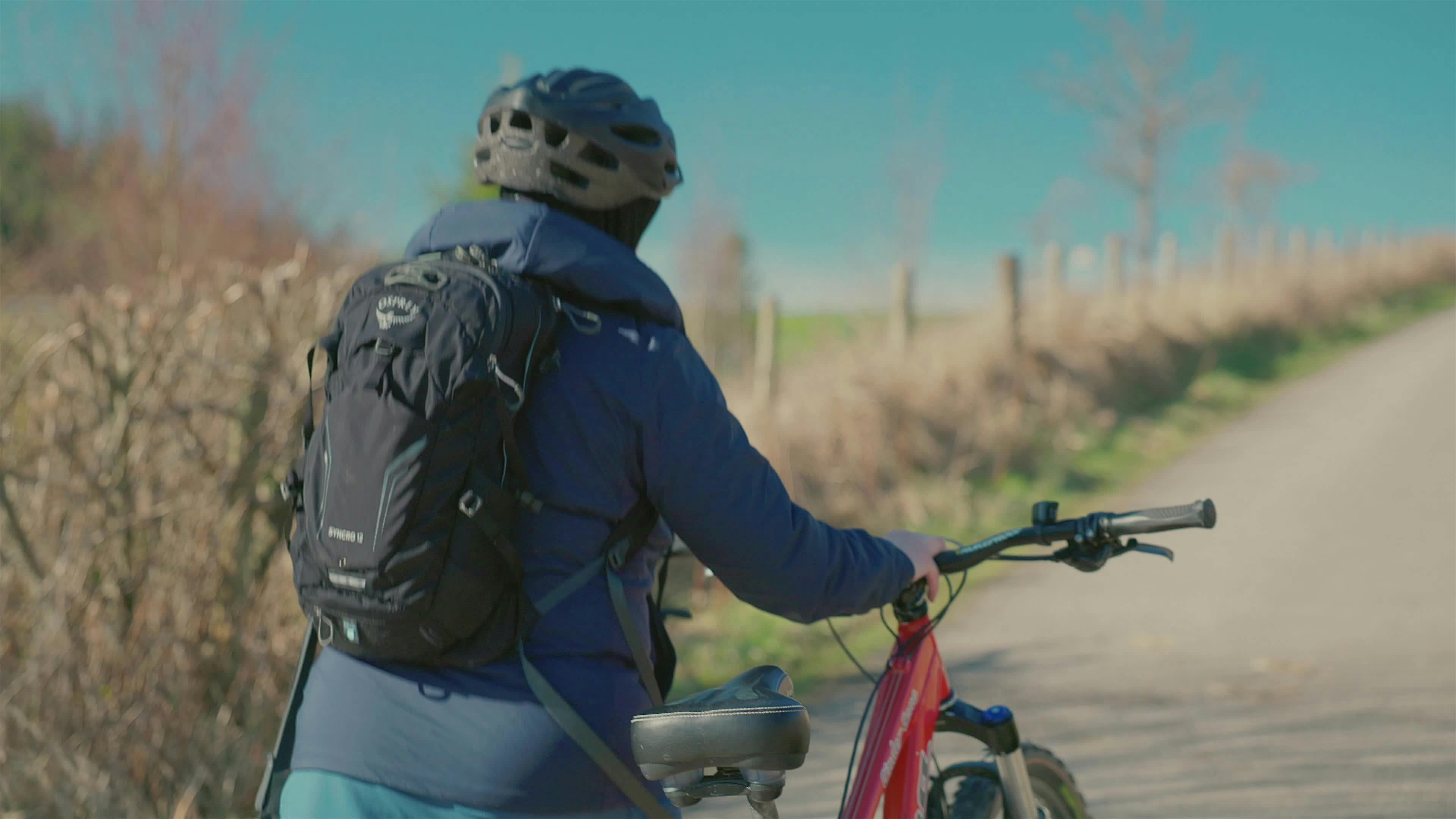A man with a backpack on a bike rides down a dirt road Free Stock Video ...