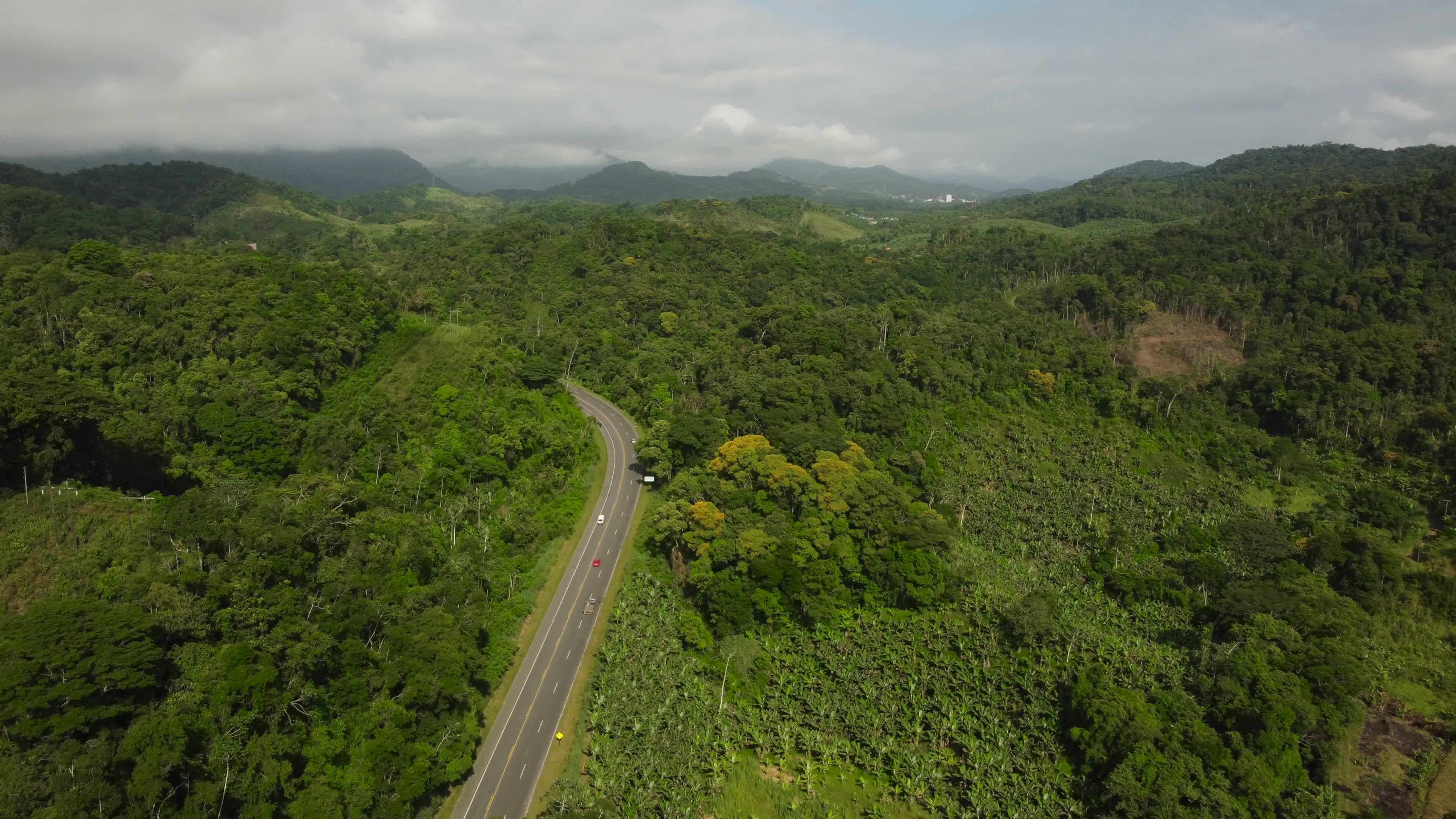 Drone footage of a highway in a landscape full of mountains Free Stock ...