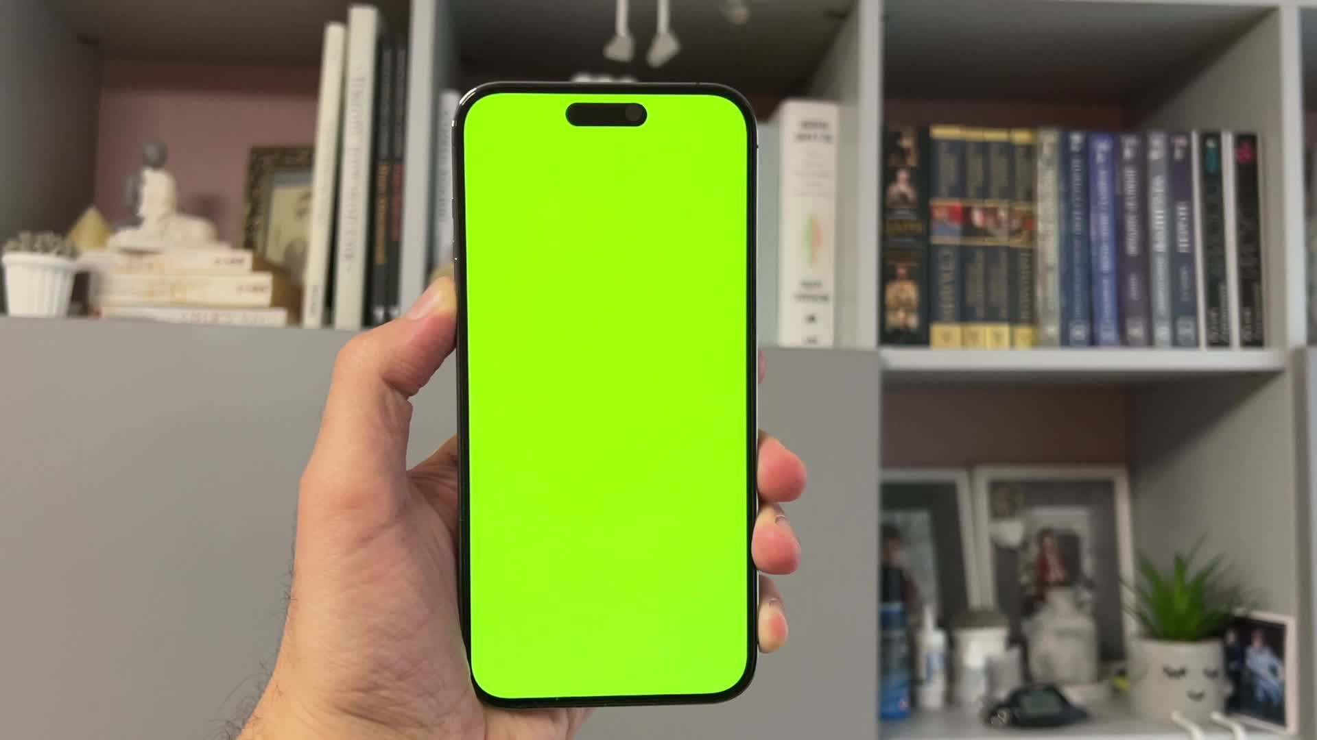 A person holding up an iphone with a green screen Free Stock Video ...