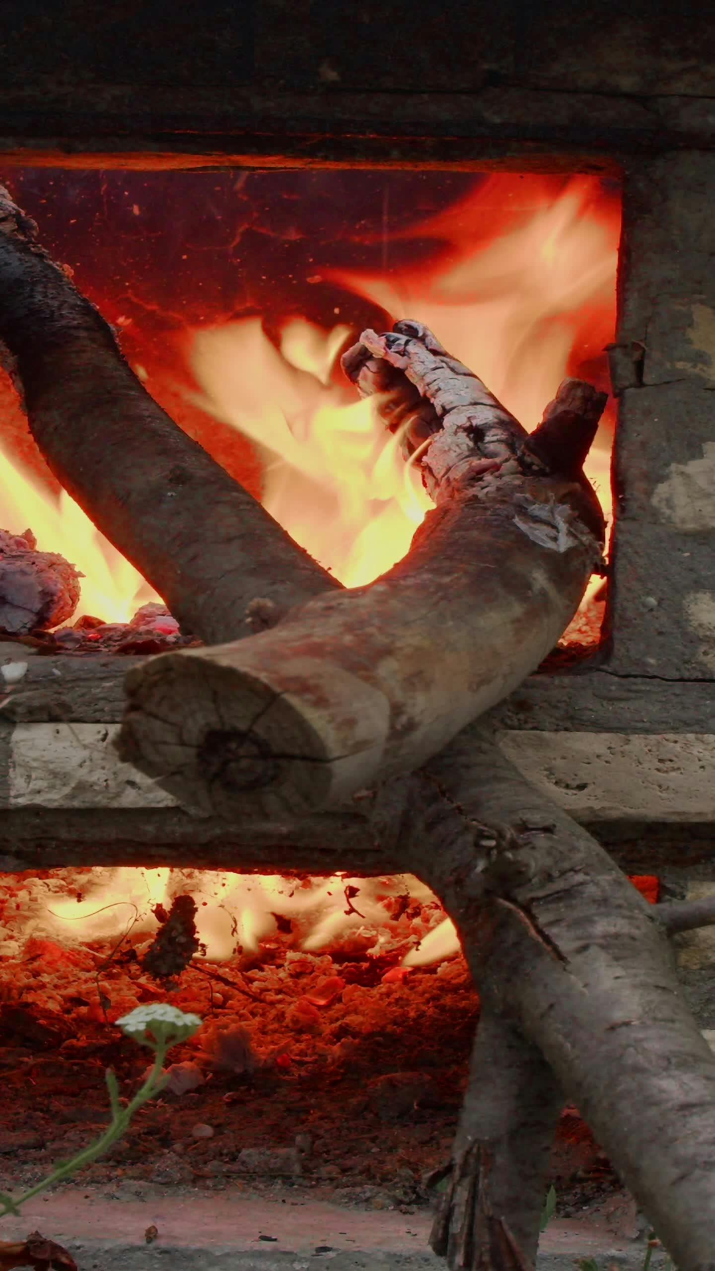 A cozy campfire crackles in a makeshift fire pit during a traditional ...