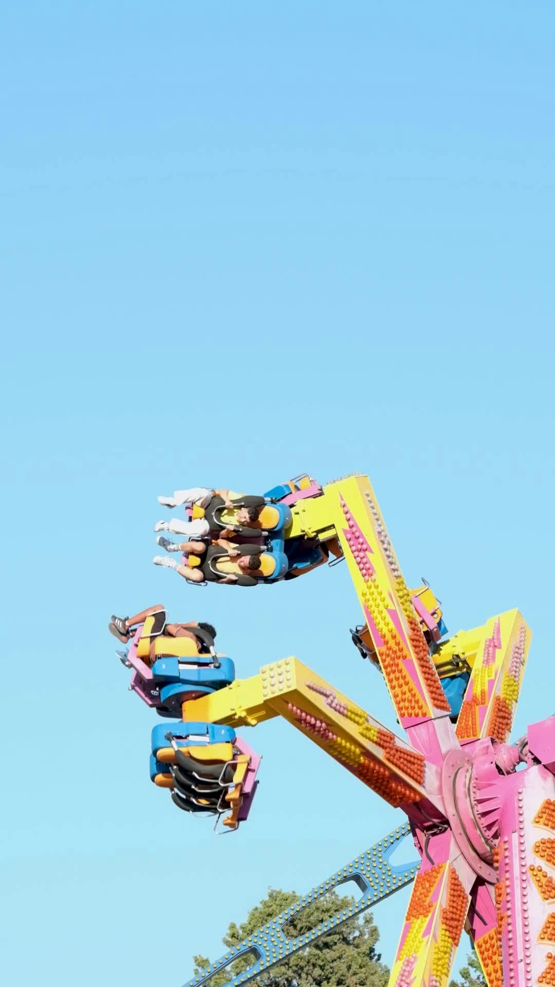 Exhilarating Carnival Ride with Colorful Arms Against Clear Blue Sky ...