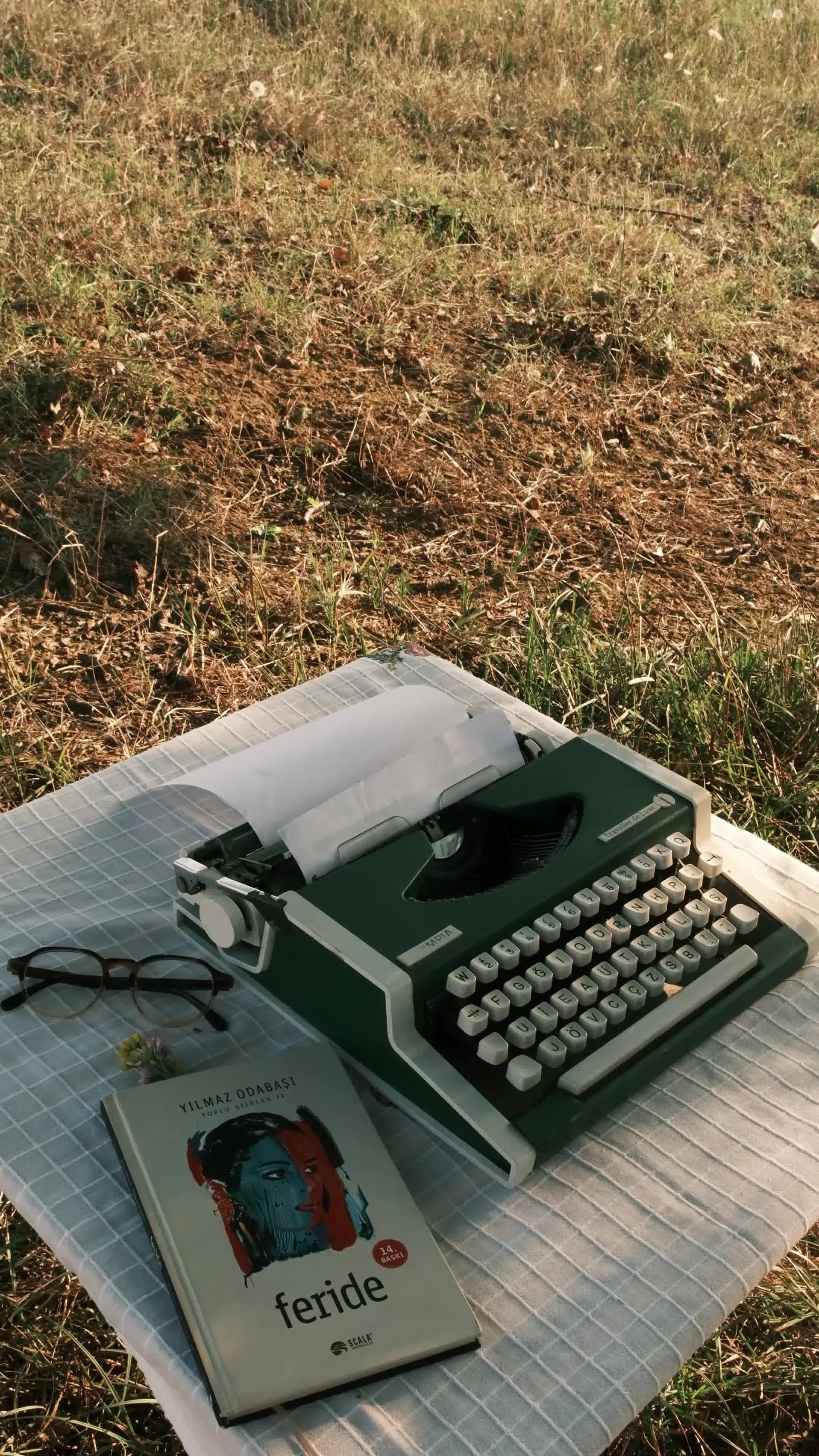 A green typewriter sitting on a table in the middle of a field Free ...