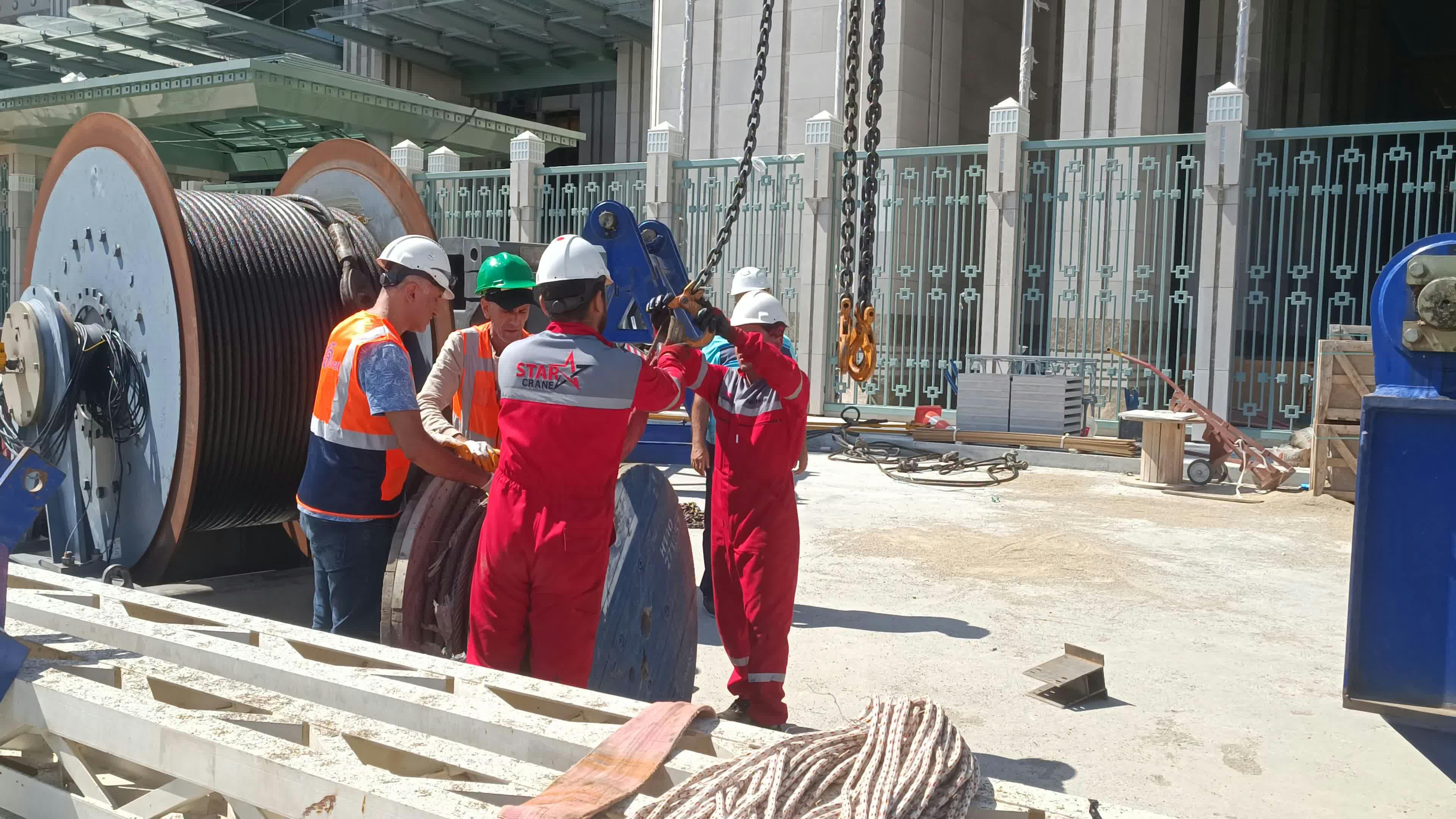 A group of men in red uniforms working on a large machine Free Stock ...