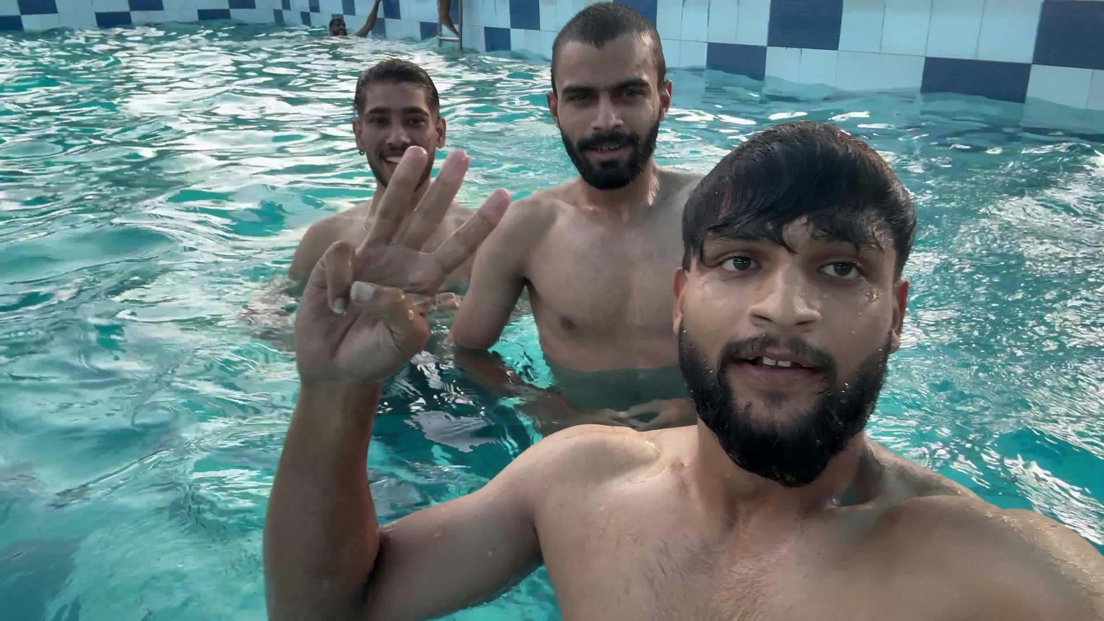 Two men swimming in the water with one pointing to his finger Free ...