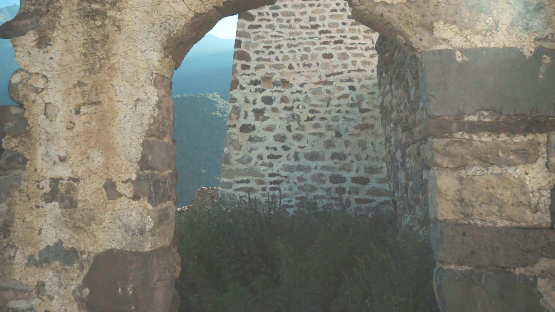 A tall tower with a stone base and a stone wall Free Stock Video ...