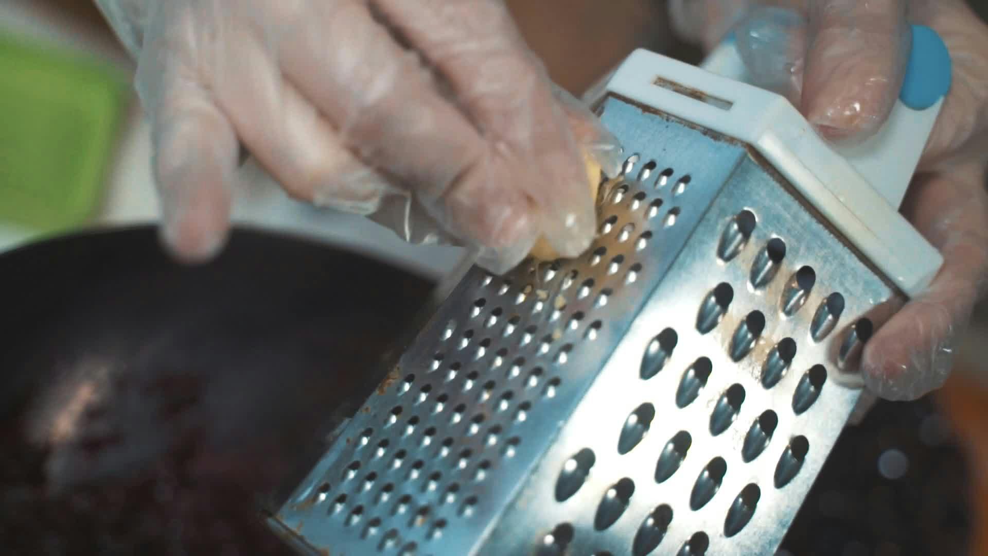 Una Persona Ralla Algo De Comida Con Un Rallador. · Vídeo de stock gratuito