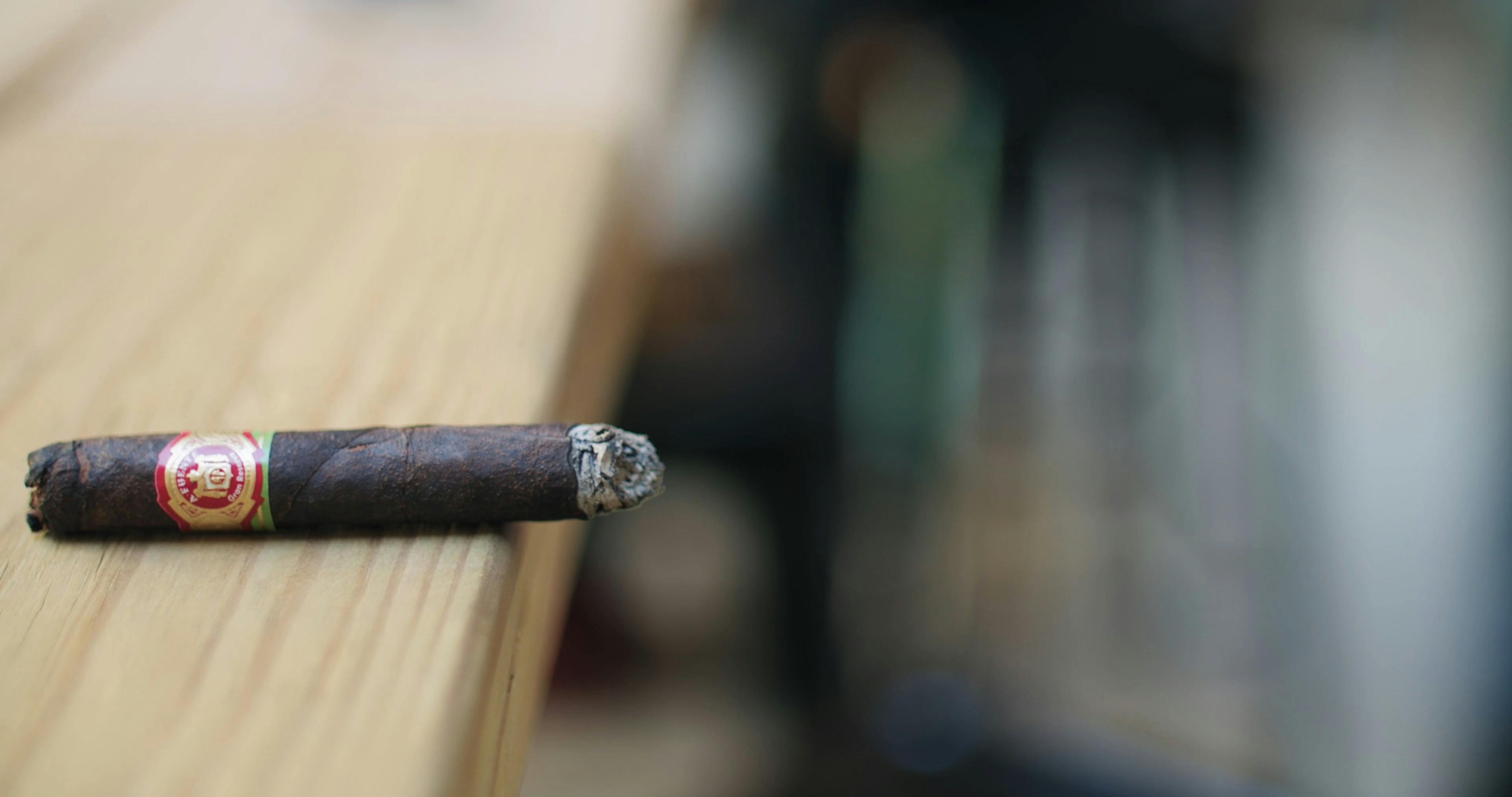 Close-up Of A Lit Cigar Placed On A Wooden Table · Free Stock Video