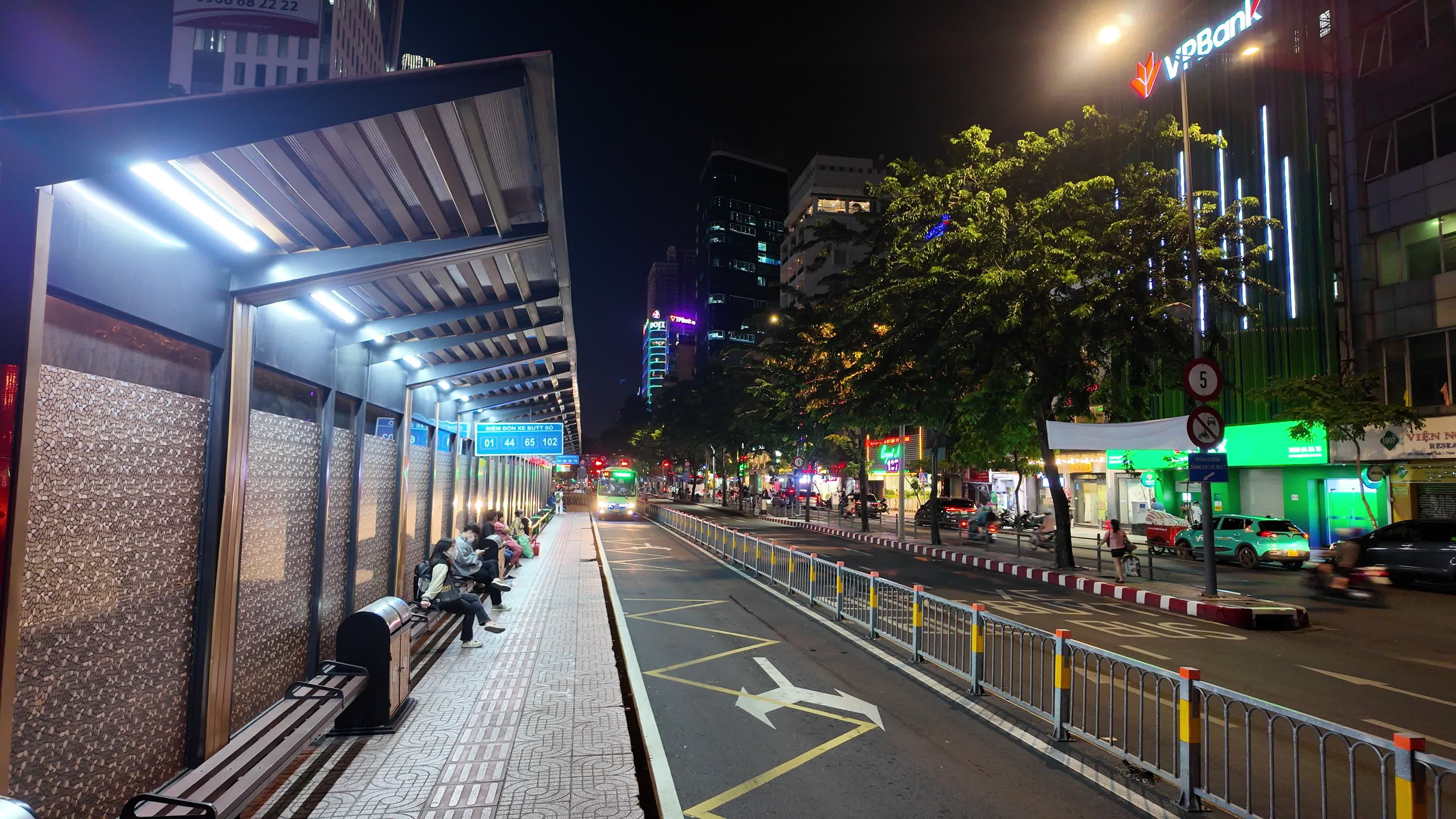 Vibrant Night Cityscape with Bustling Bus Stop Free Stock Video Footage ...