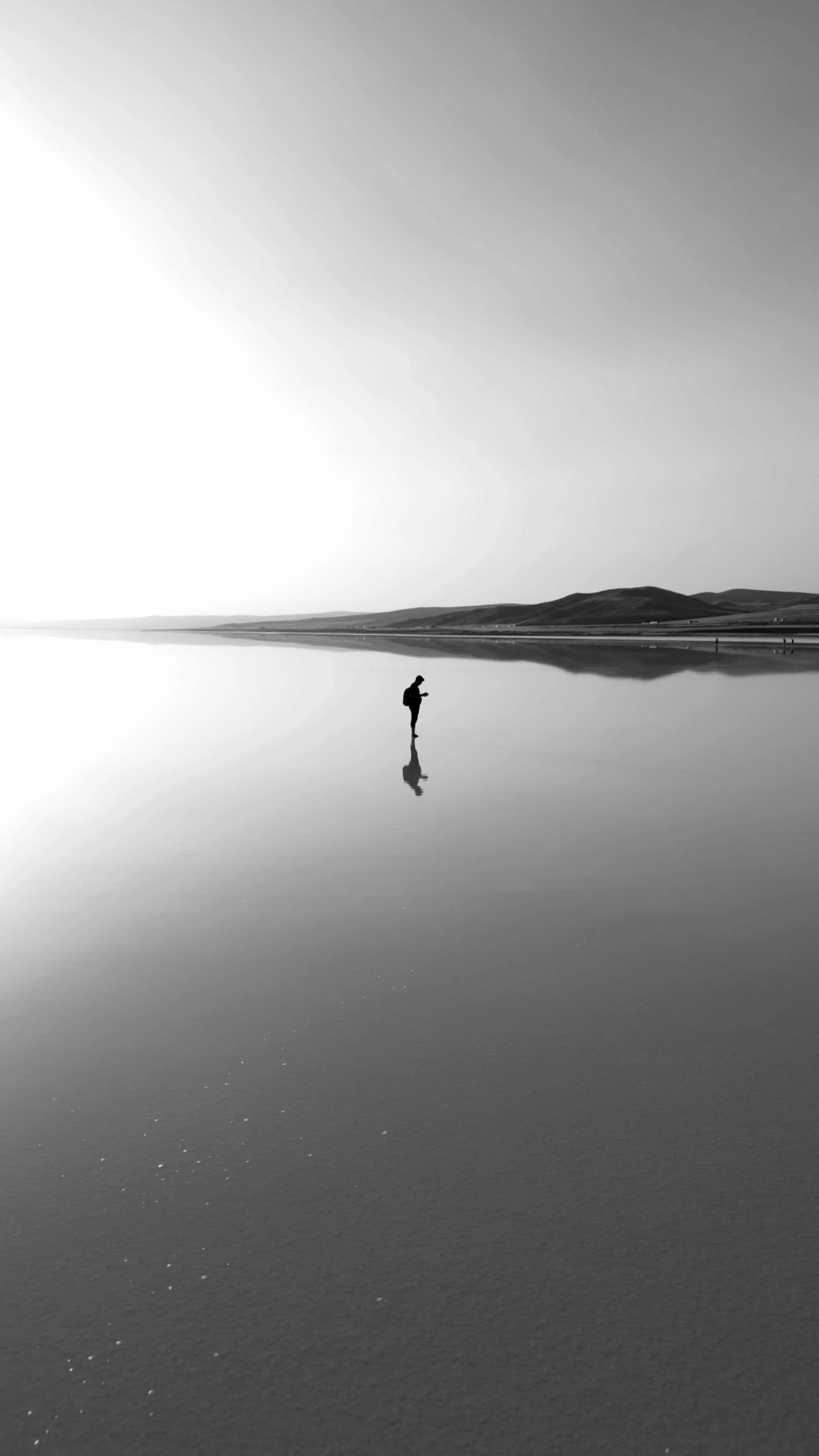Solitary Figure Walking on Vast Mirror-Like Surface Free Stock Video ...