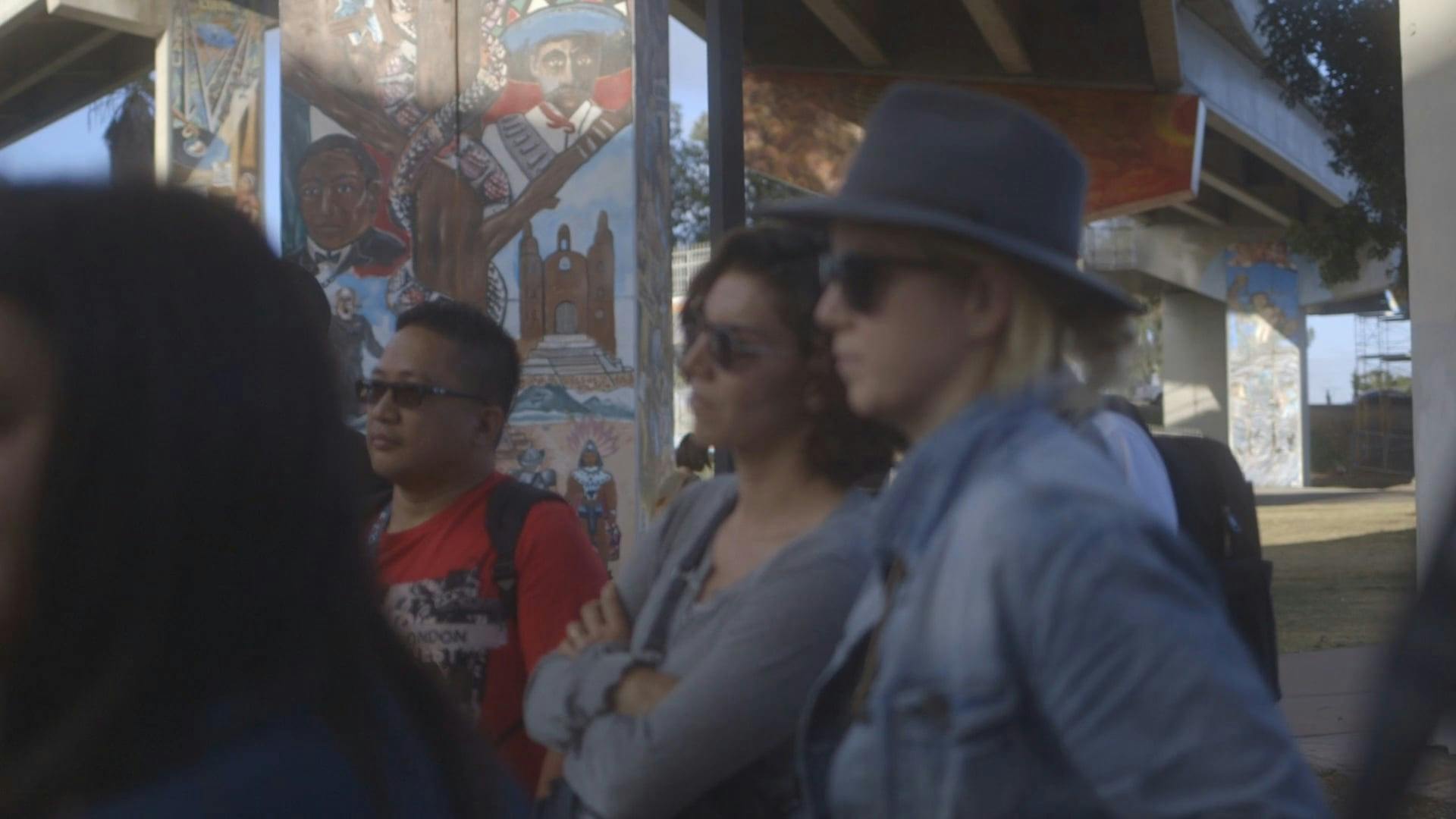 A Crowd Of People Gathered Watching Something In A Street Under A ...