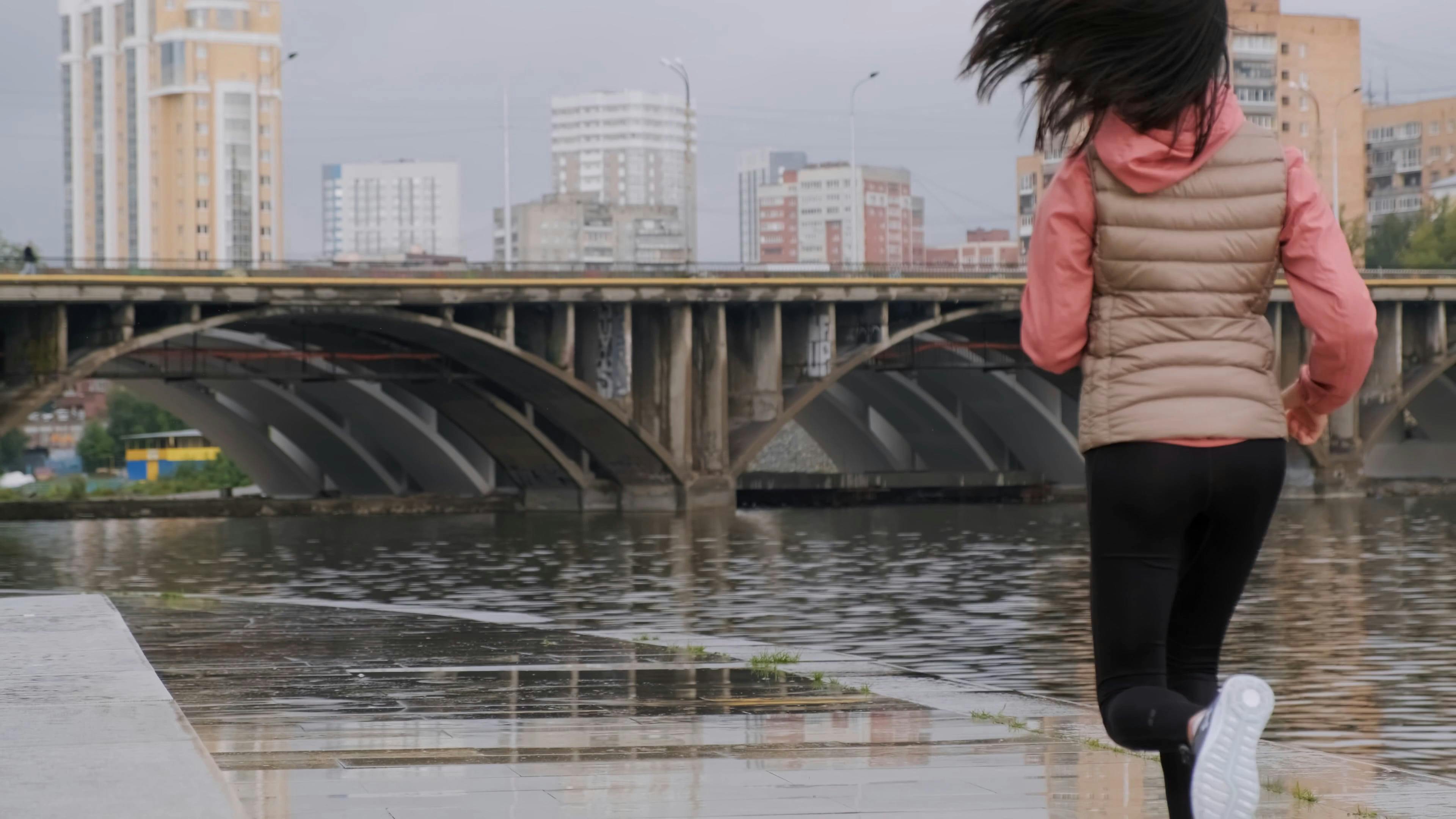 A Woman Running On The Pavement Of A River Bank Free Stock Video ...