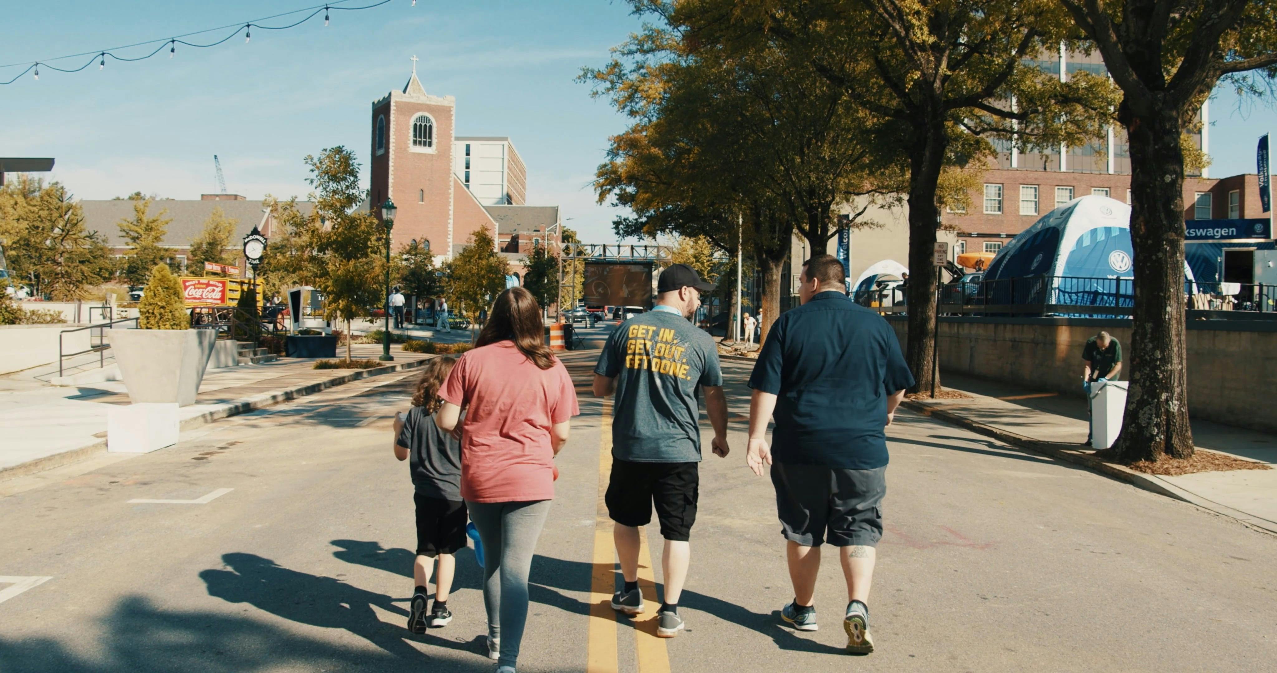 A Group Of People Walking Down The Road Leading To A Church Free Stock ...