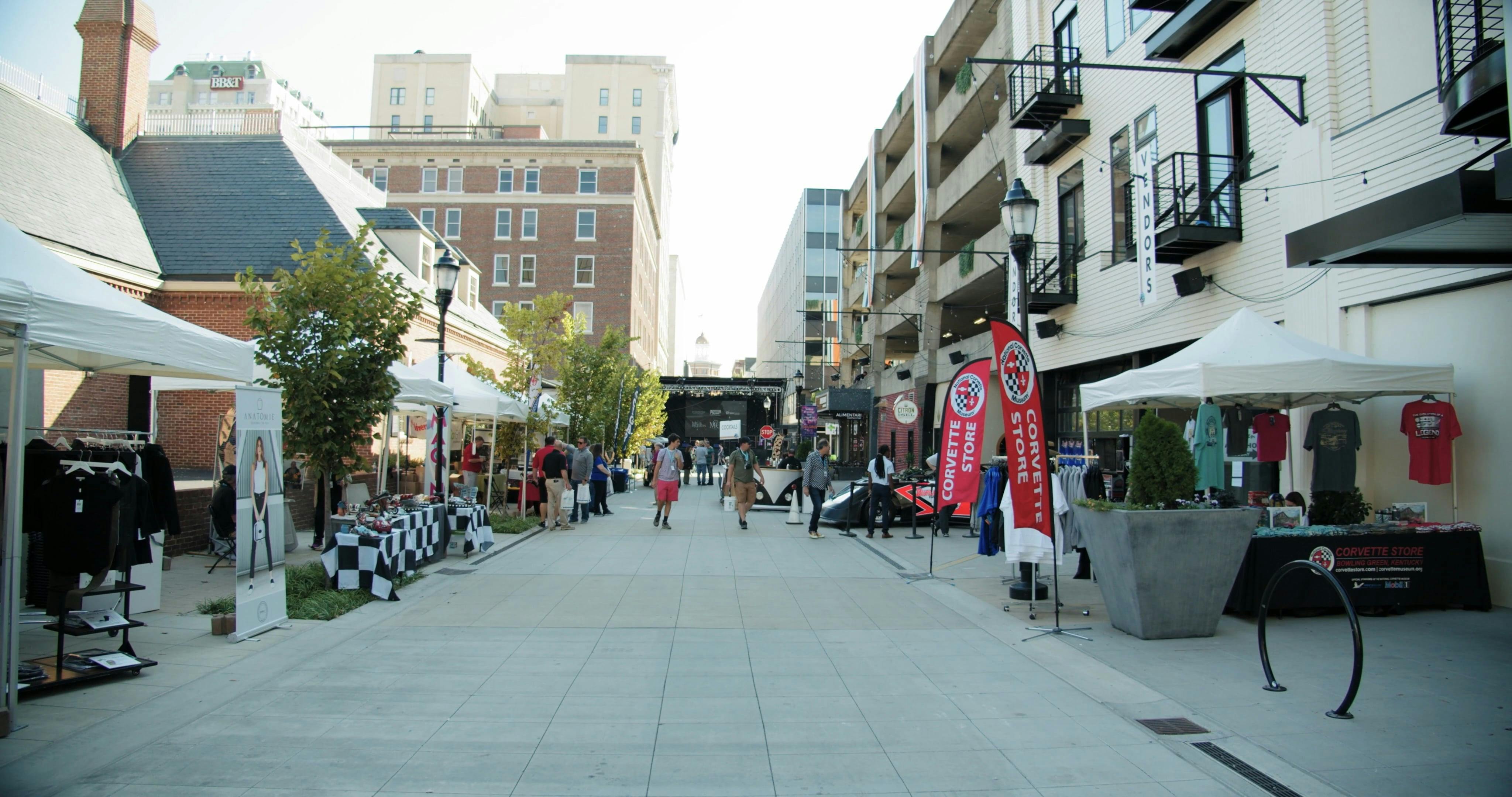 People Walking On In An Alley Lined With Tents Stores Selling Assorted ...