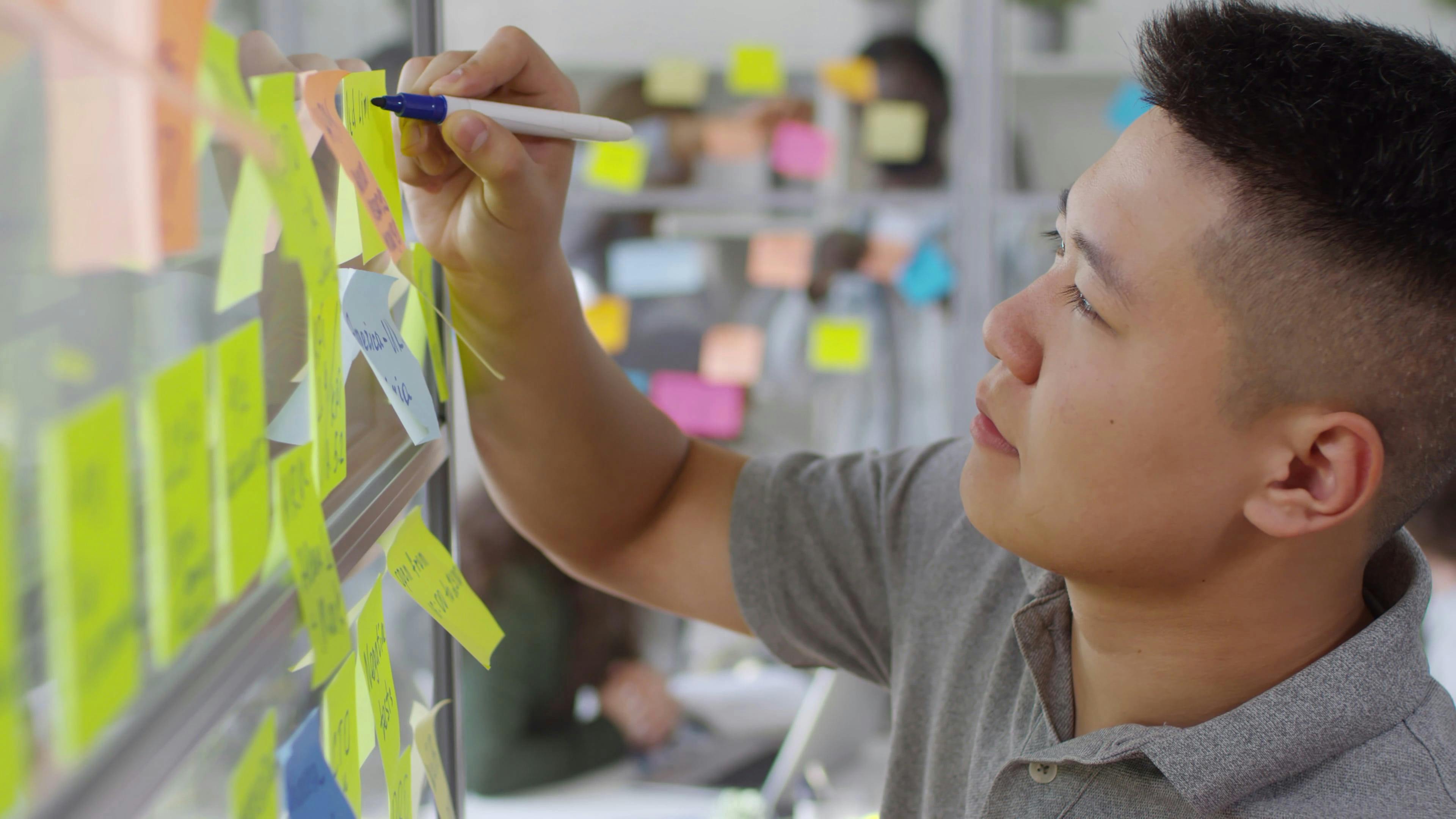 A Man Writing A Note On A Stick Paper Pad · Free Stock Video
