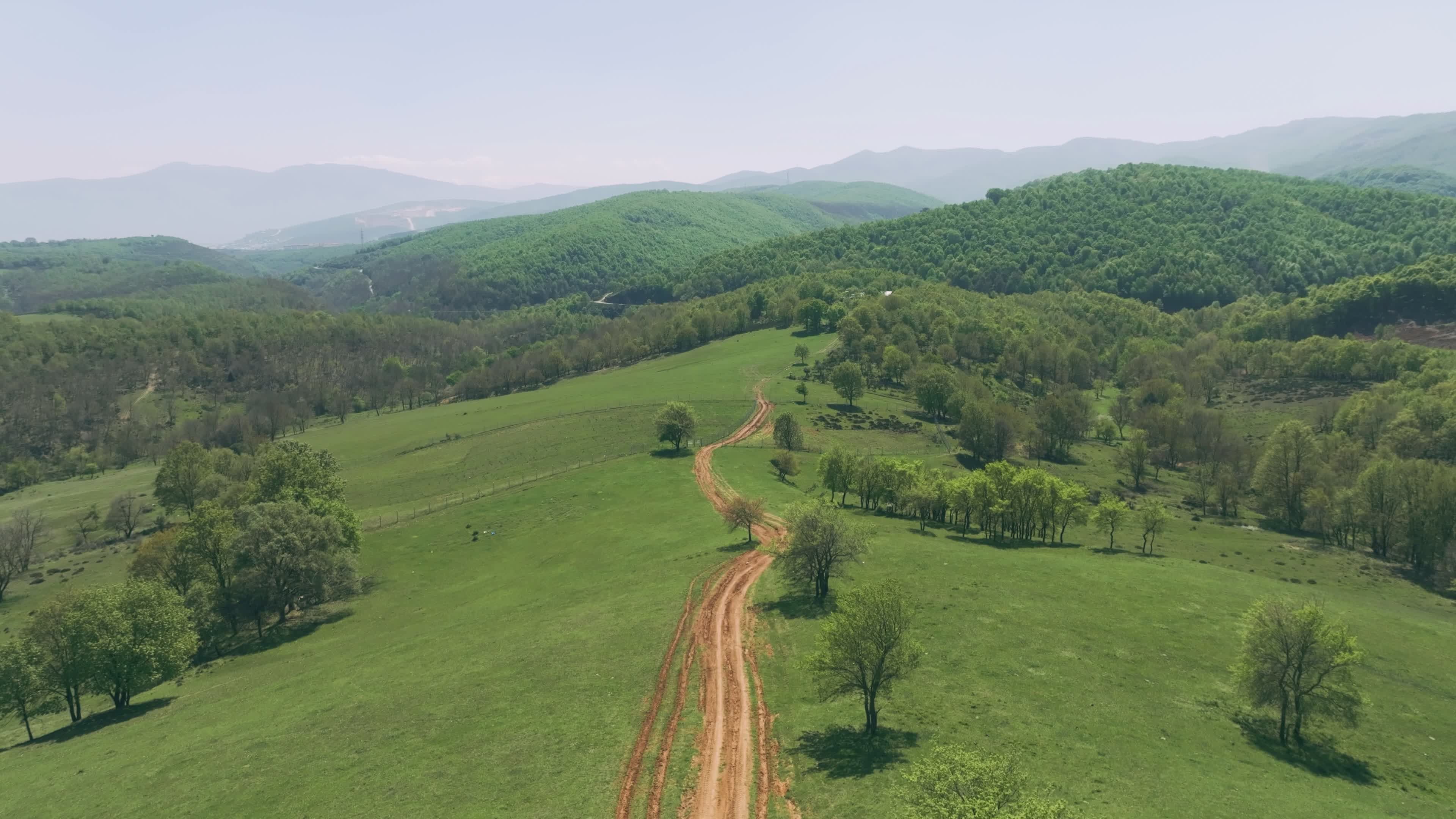 Serene Aerial View of Green Hills and Dirt Path Free Stock Video ...
