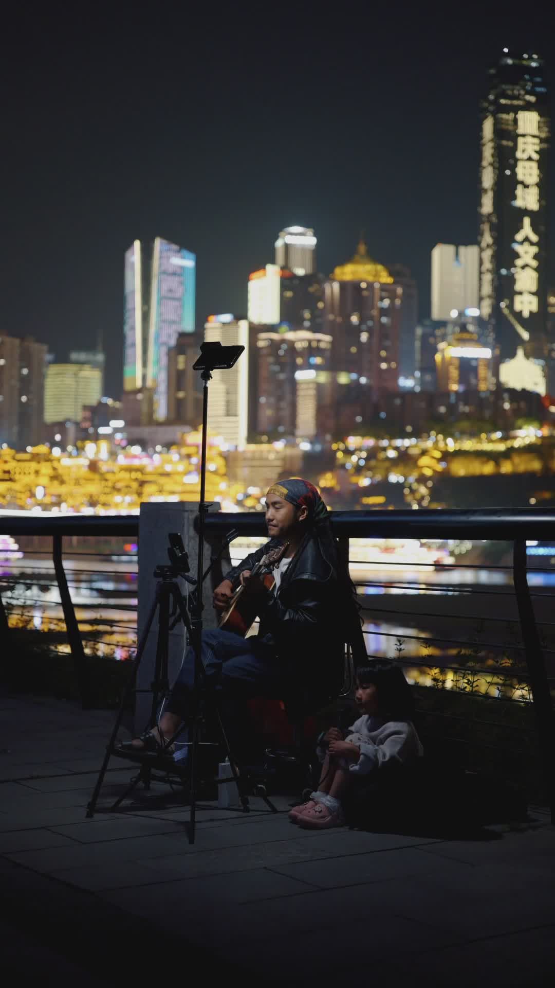 Street Performer Playing Guitar at Night with City Skyline Free Stock ...